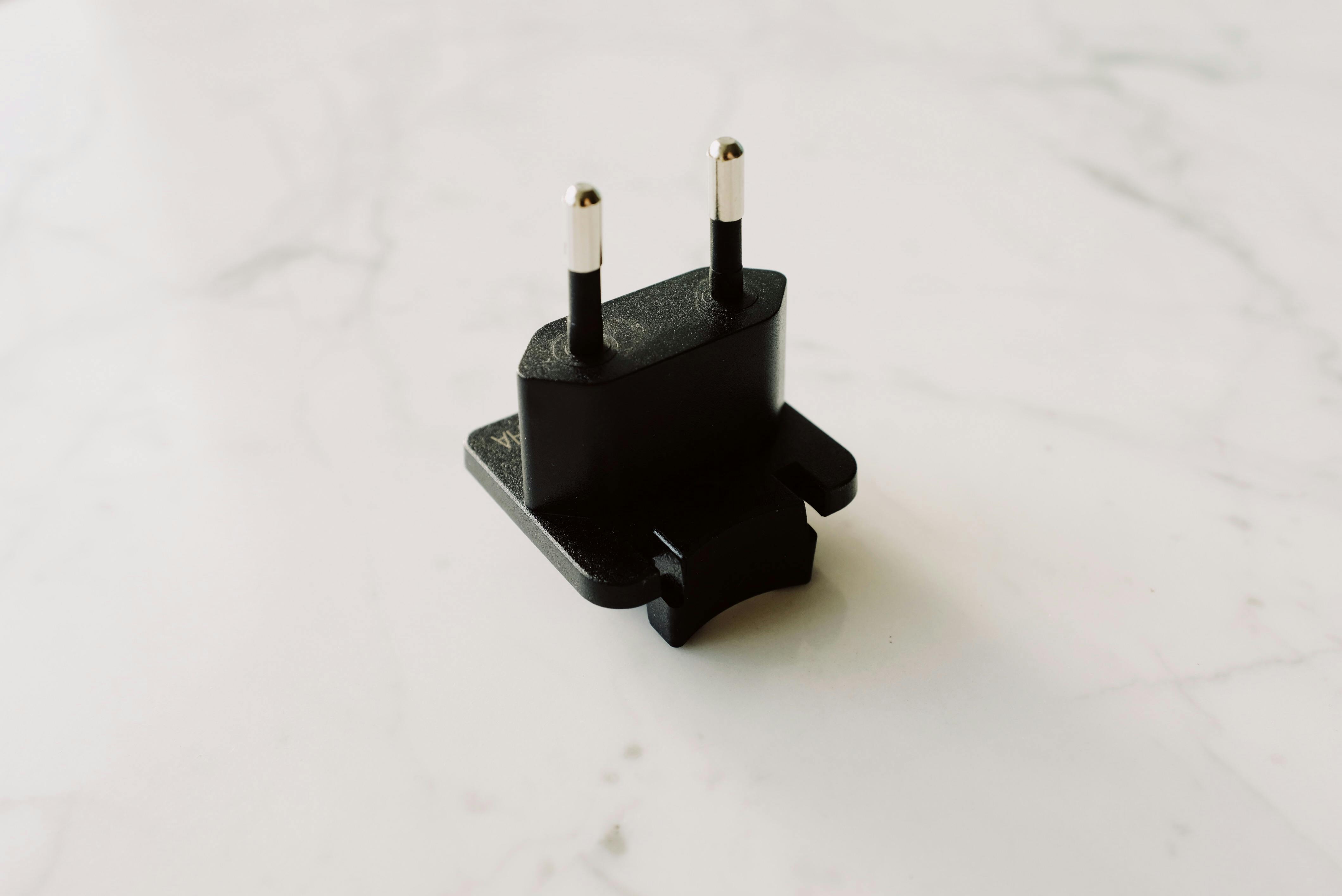 Black Adapter On White Surface · Free Stock Photo