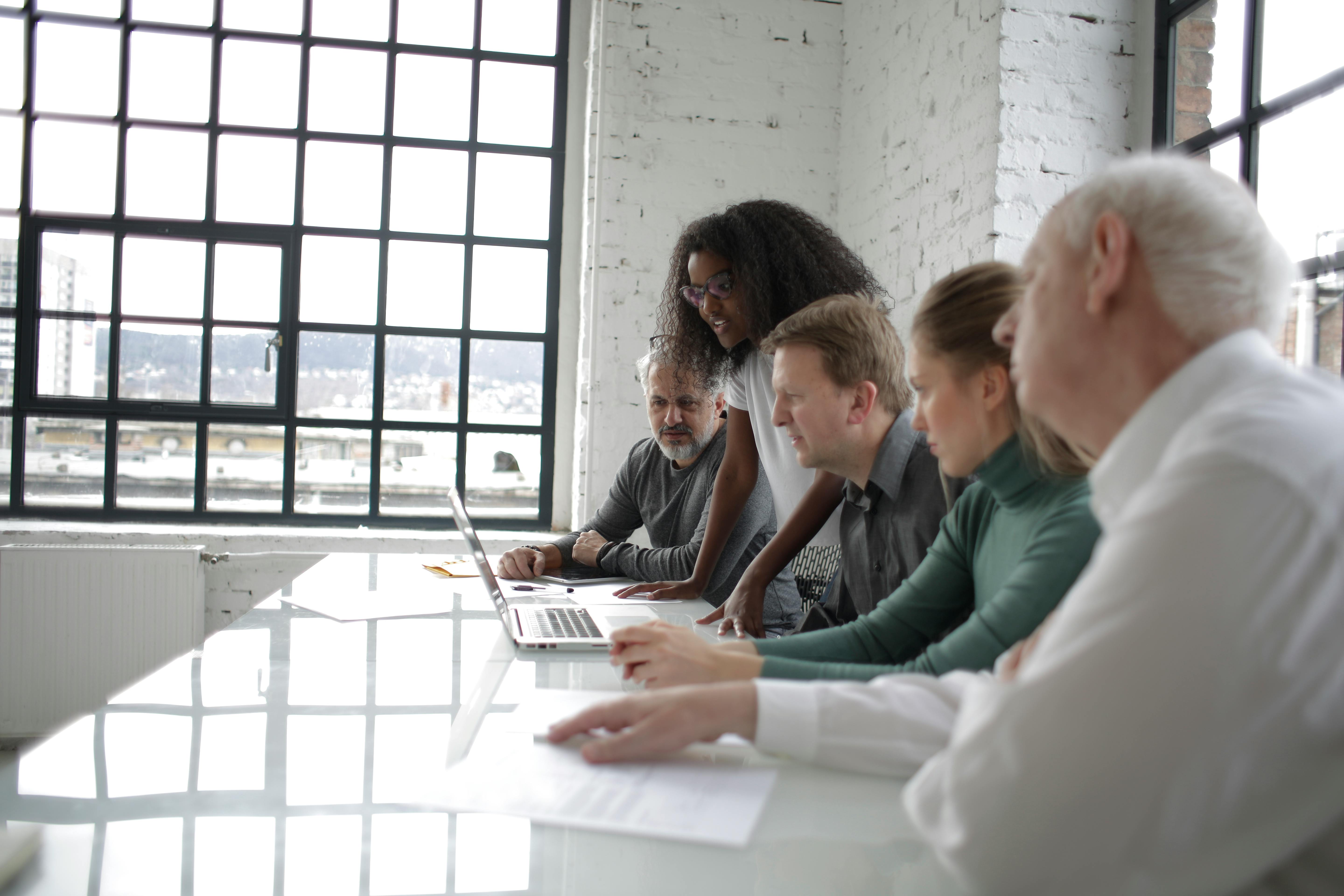 Focused multiracial coworkers of different ages using laptop and ...