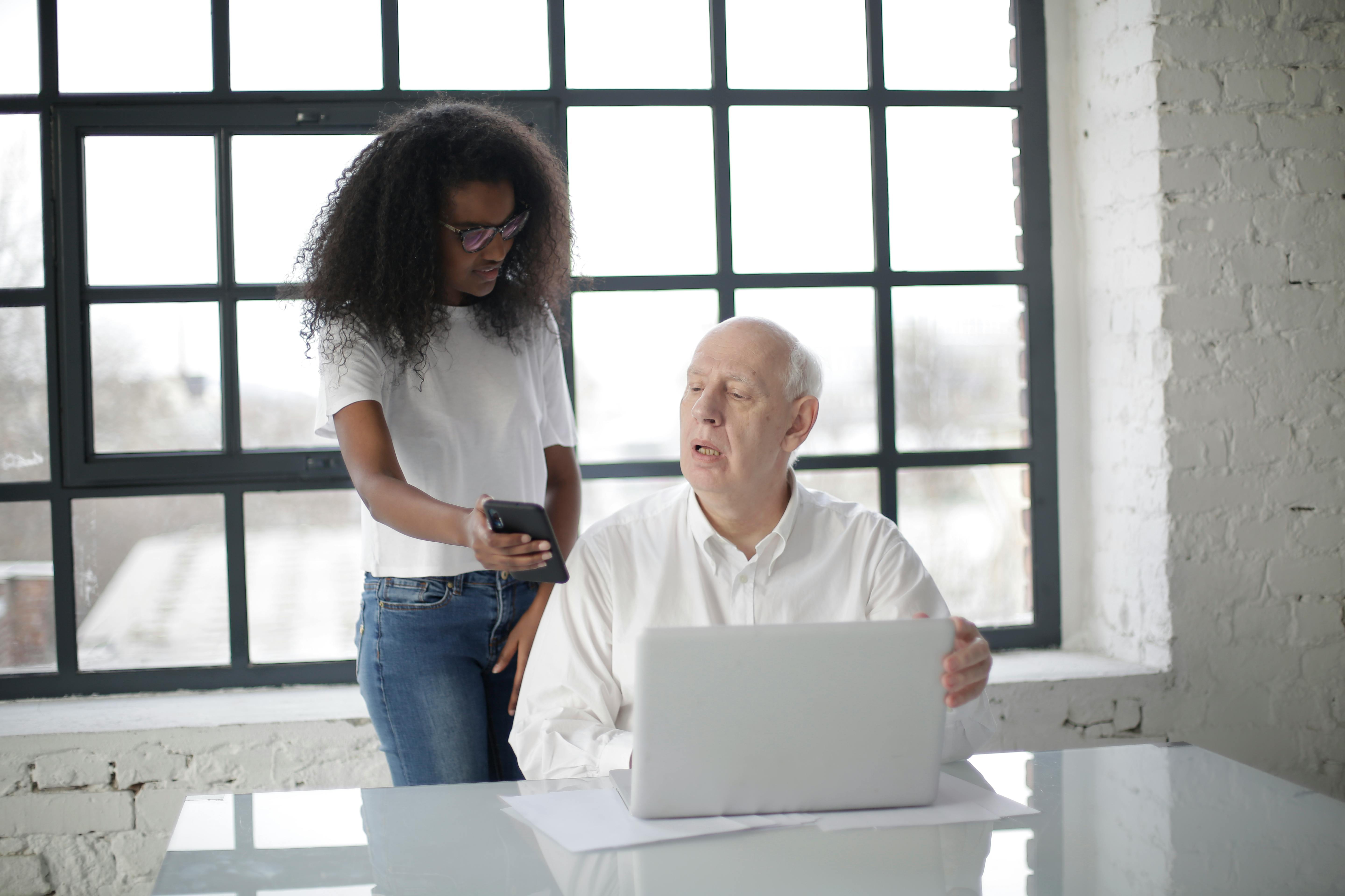 Serious diverse colleagues using gadgets while discussing project in ...