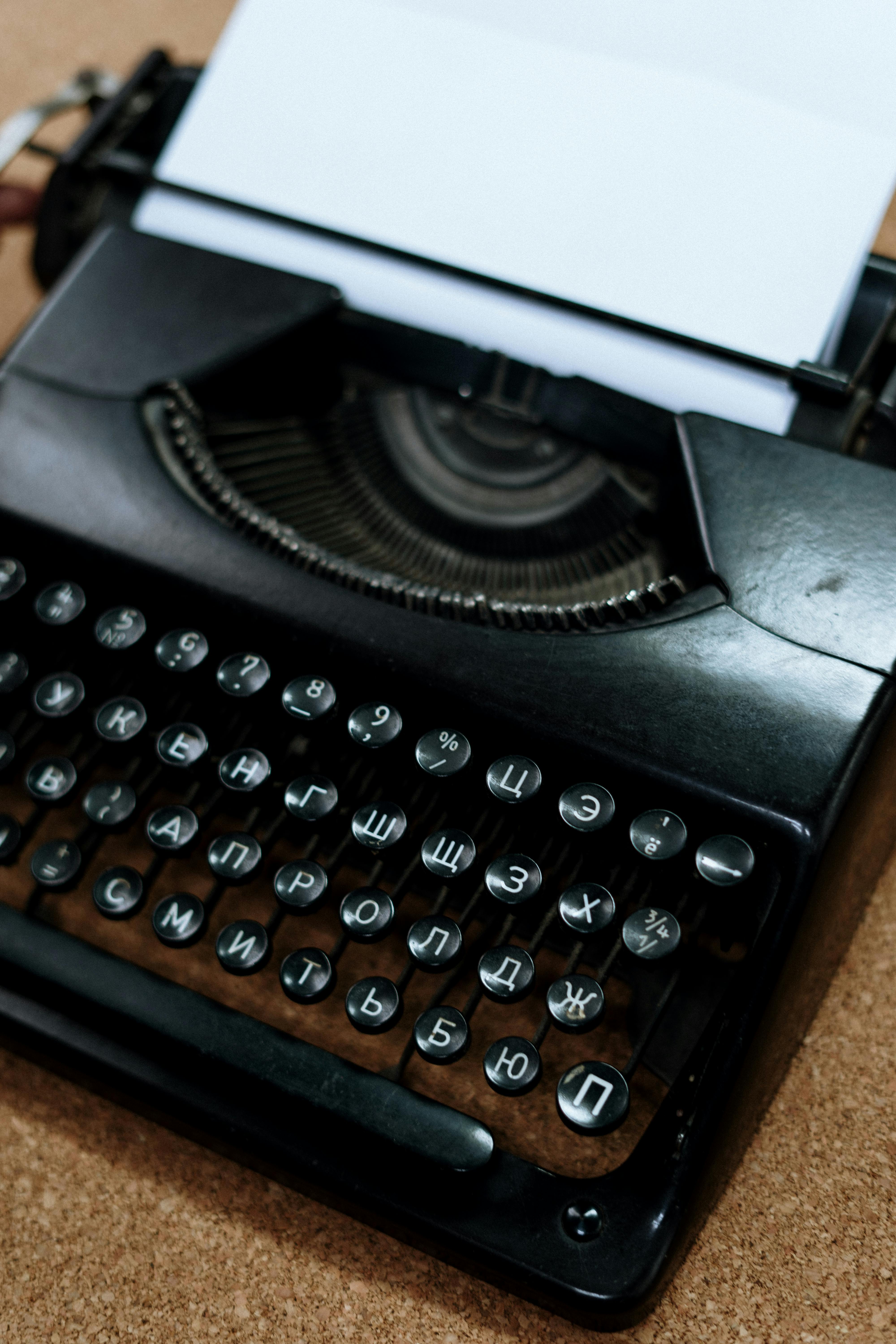 Person Holding Black Typewriter on Brown Carpet · Free Stock Photo