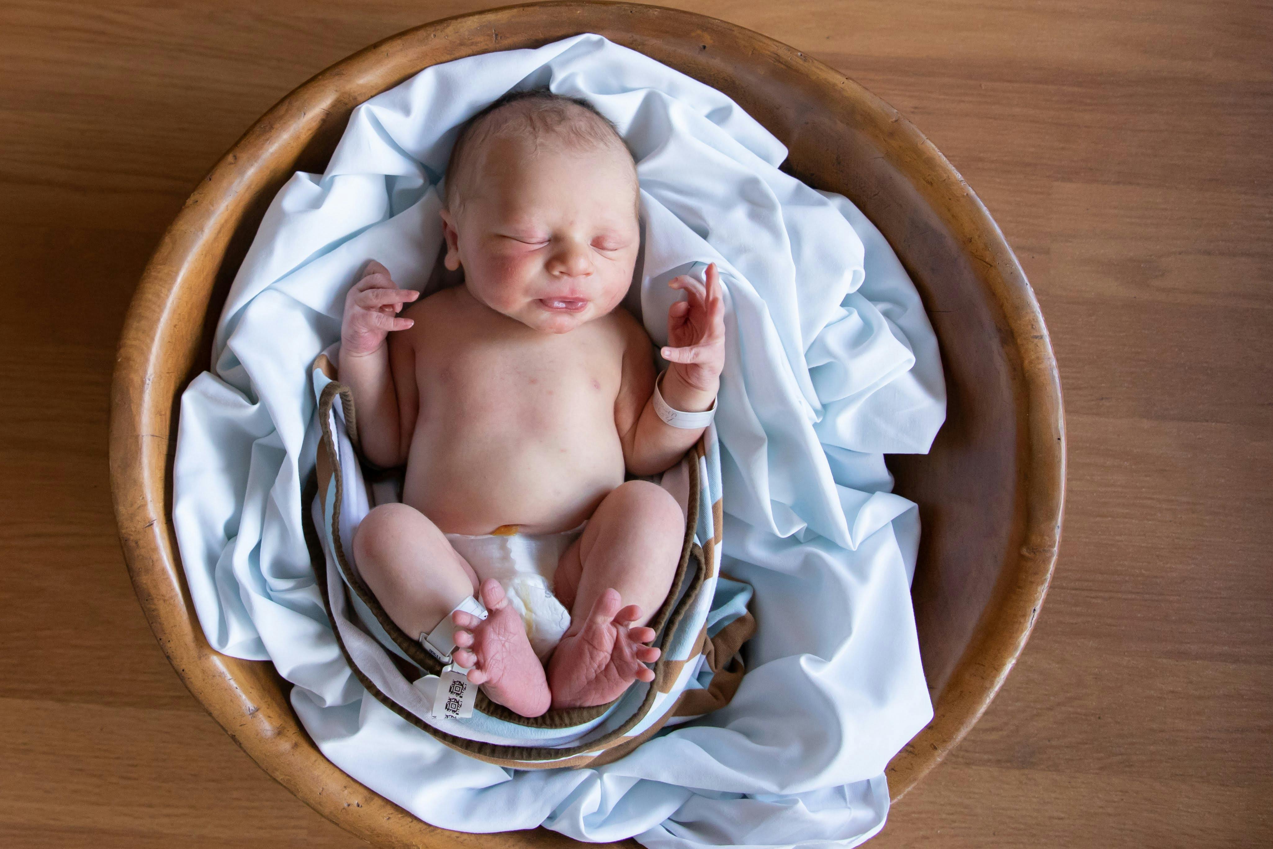 Baby Lying On White Textile · Free Stock Photo