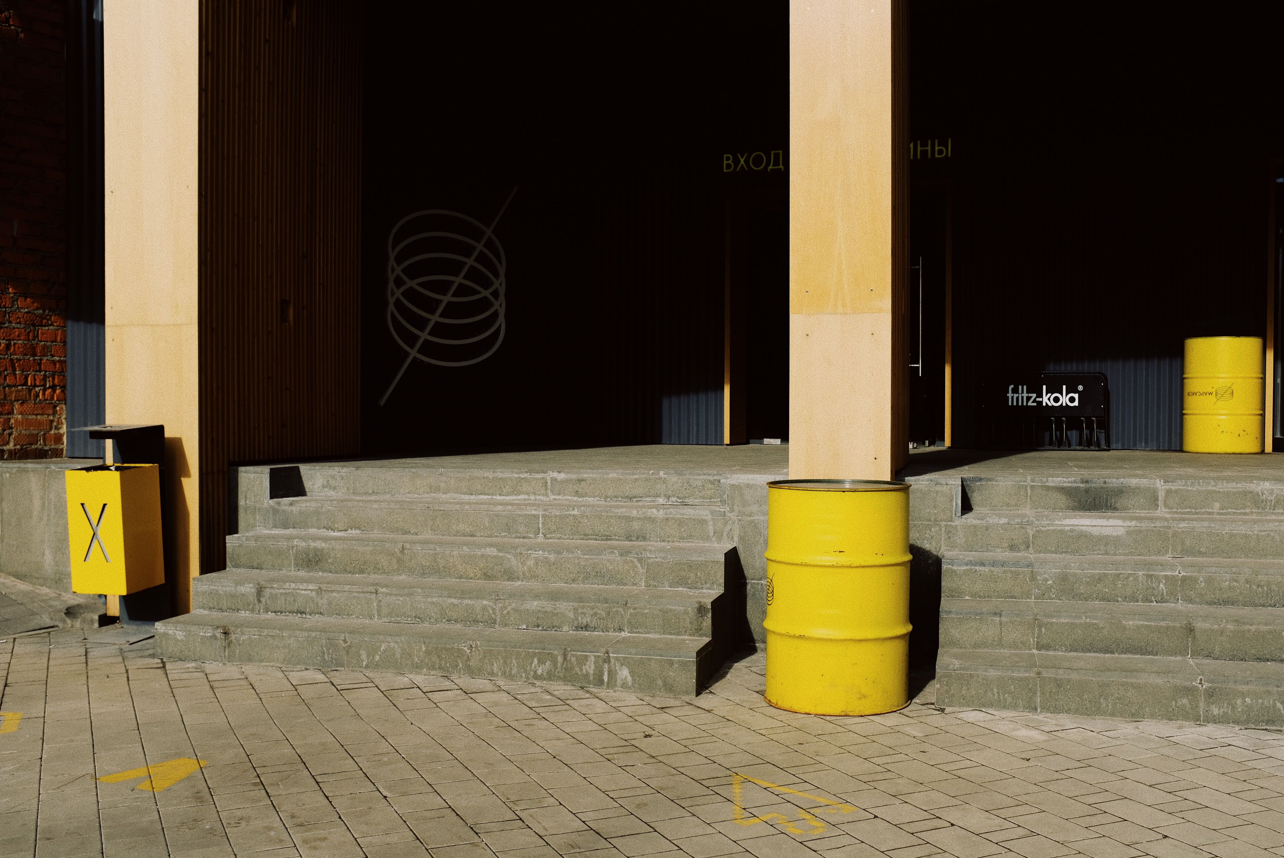 Exterior of modern building with yellow metal trash bins · Free Stock Photo