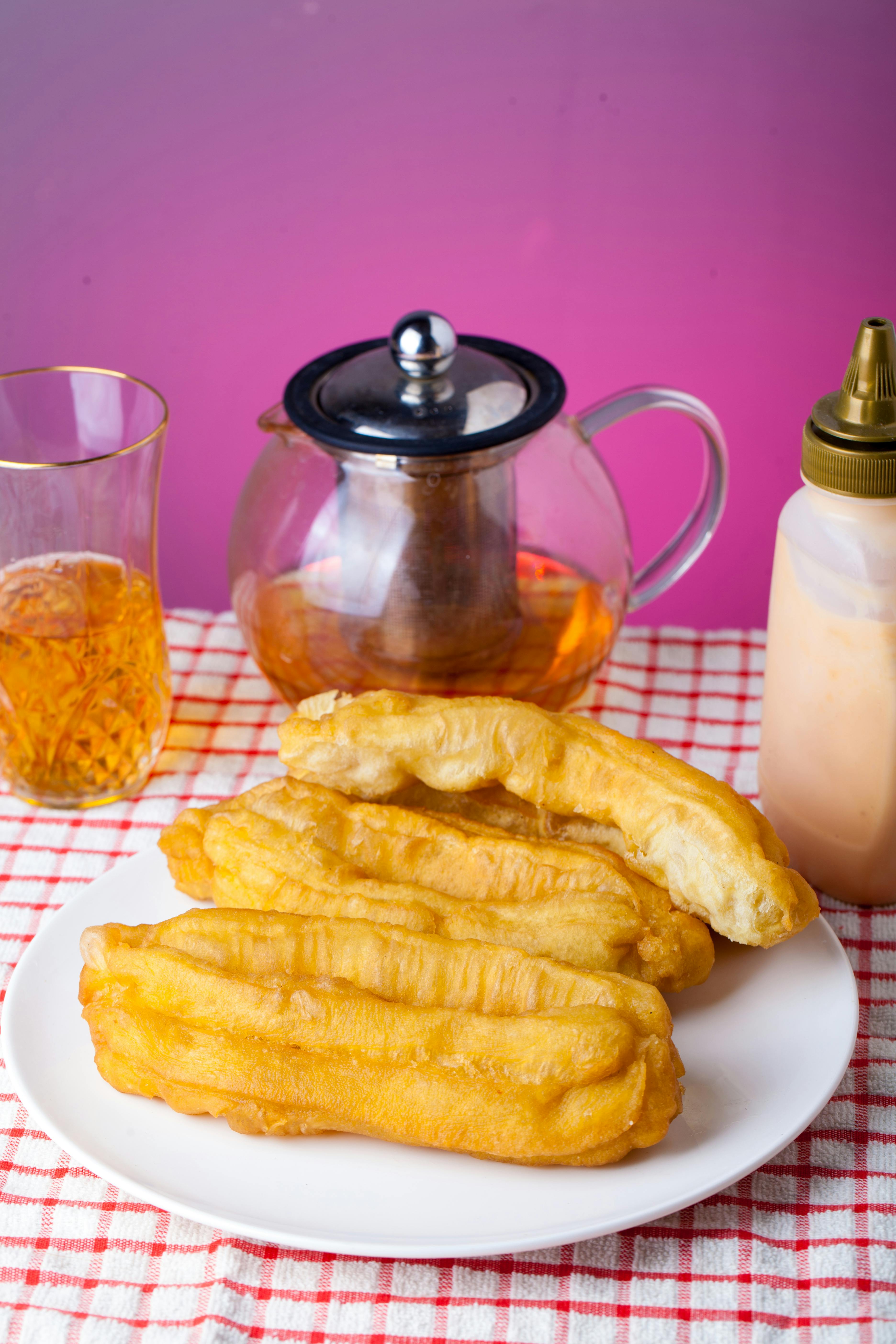 Clear Glass Pitcher Beside Bread on White and Red Checkered Table Cloth ...