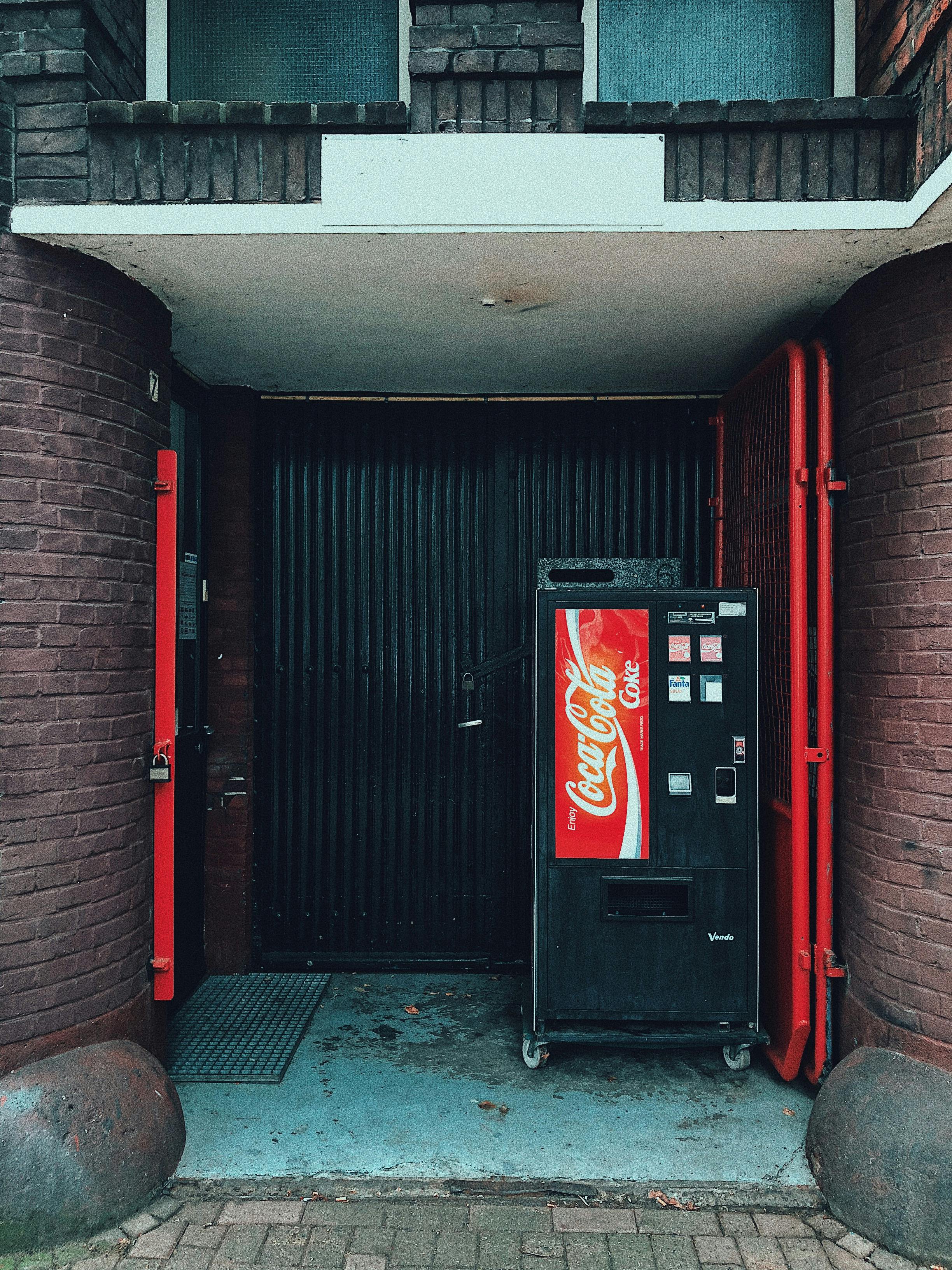 Vending Machine Beside Black Wooden Door · Free Stock Photo