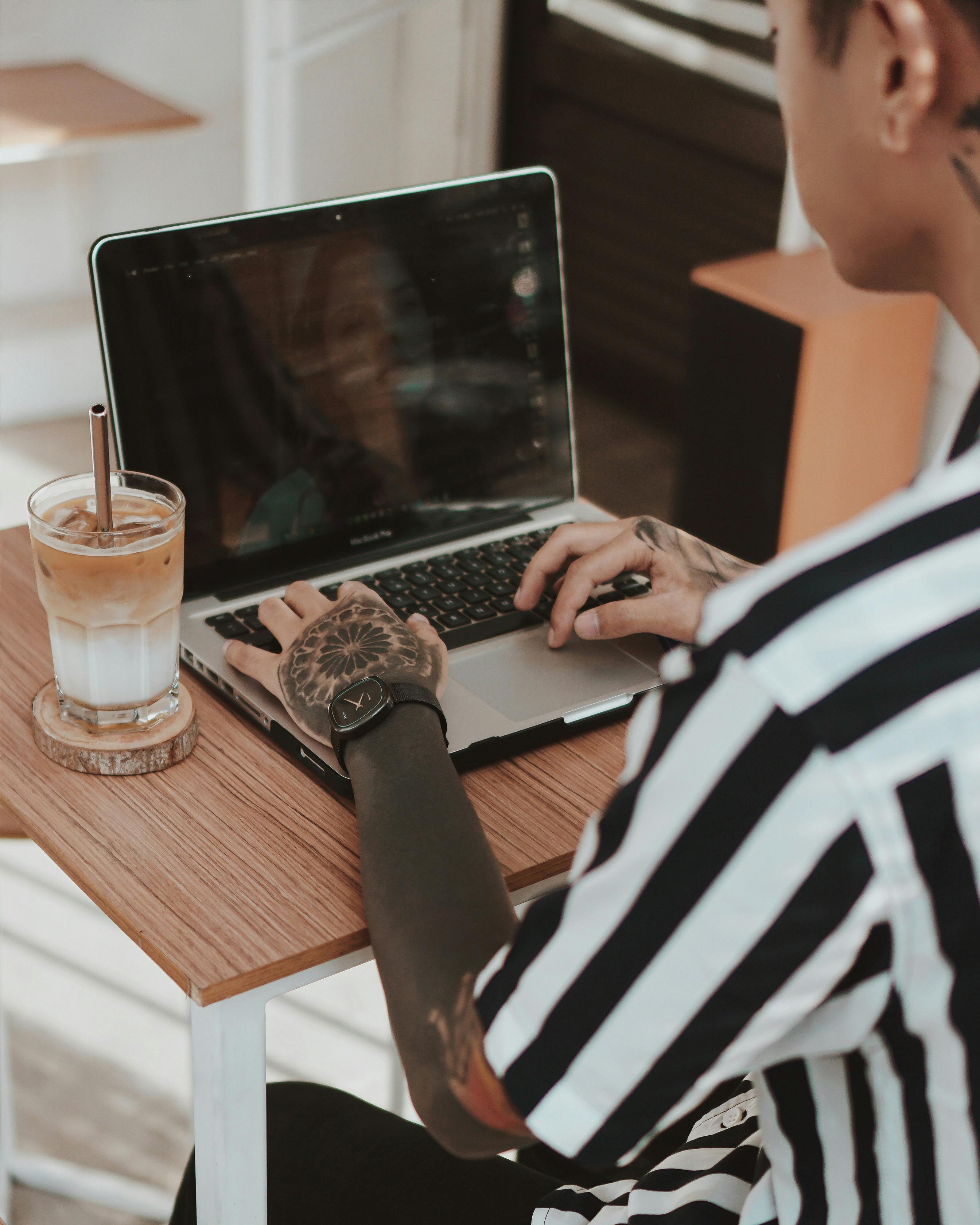 Person In Black And White Stripe Shirt Using Macbook Pro · Free Stock Photo