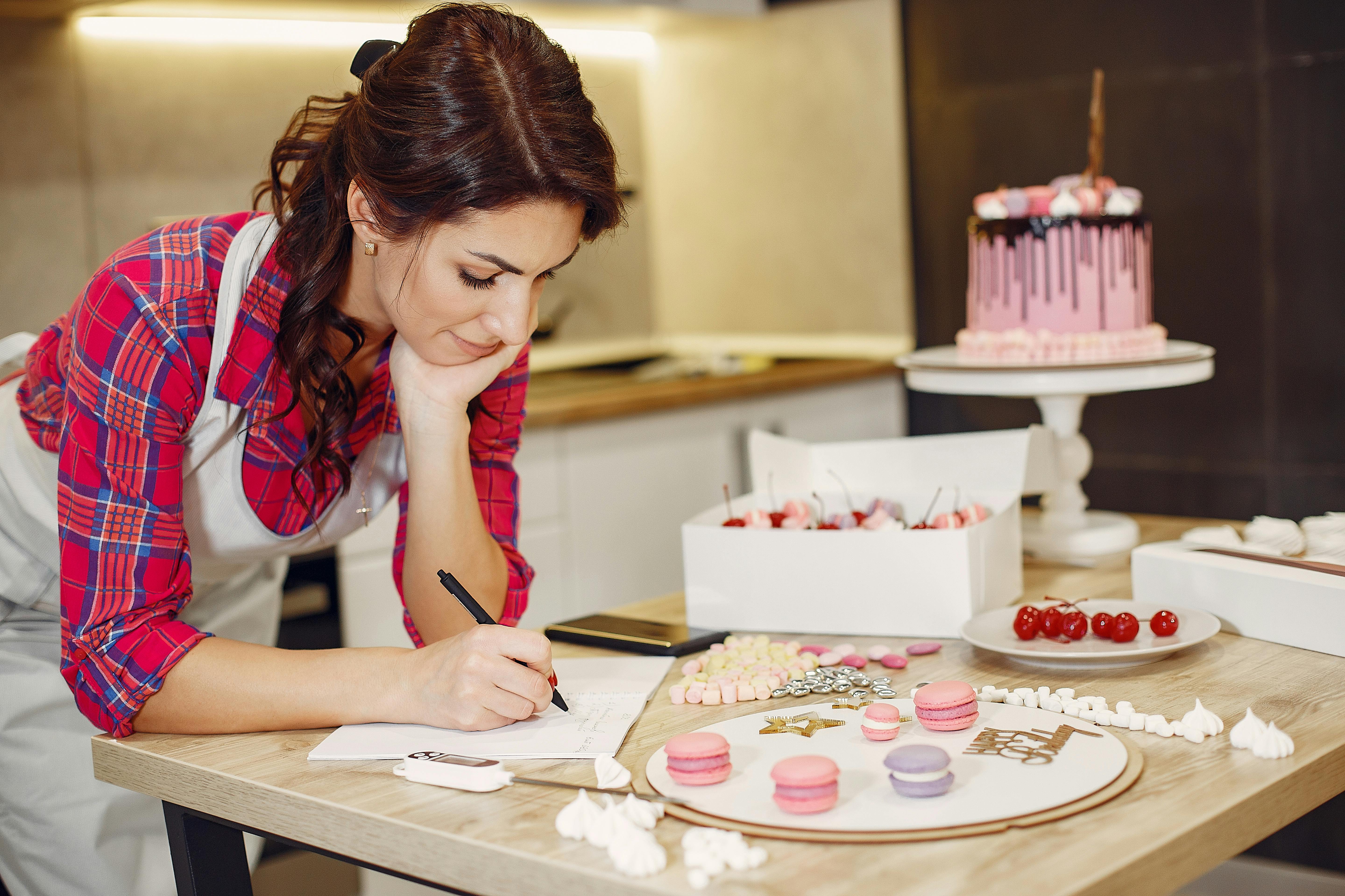 Woman taking notes standing in kitchen · Free Stock Photo