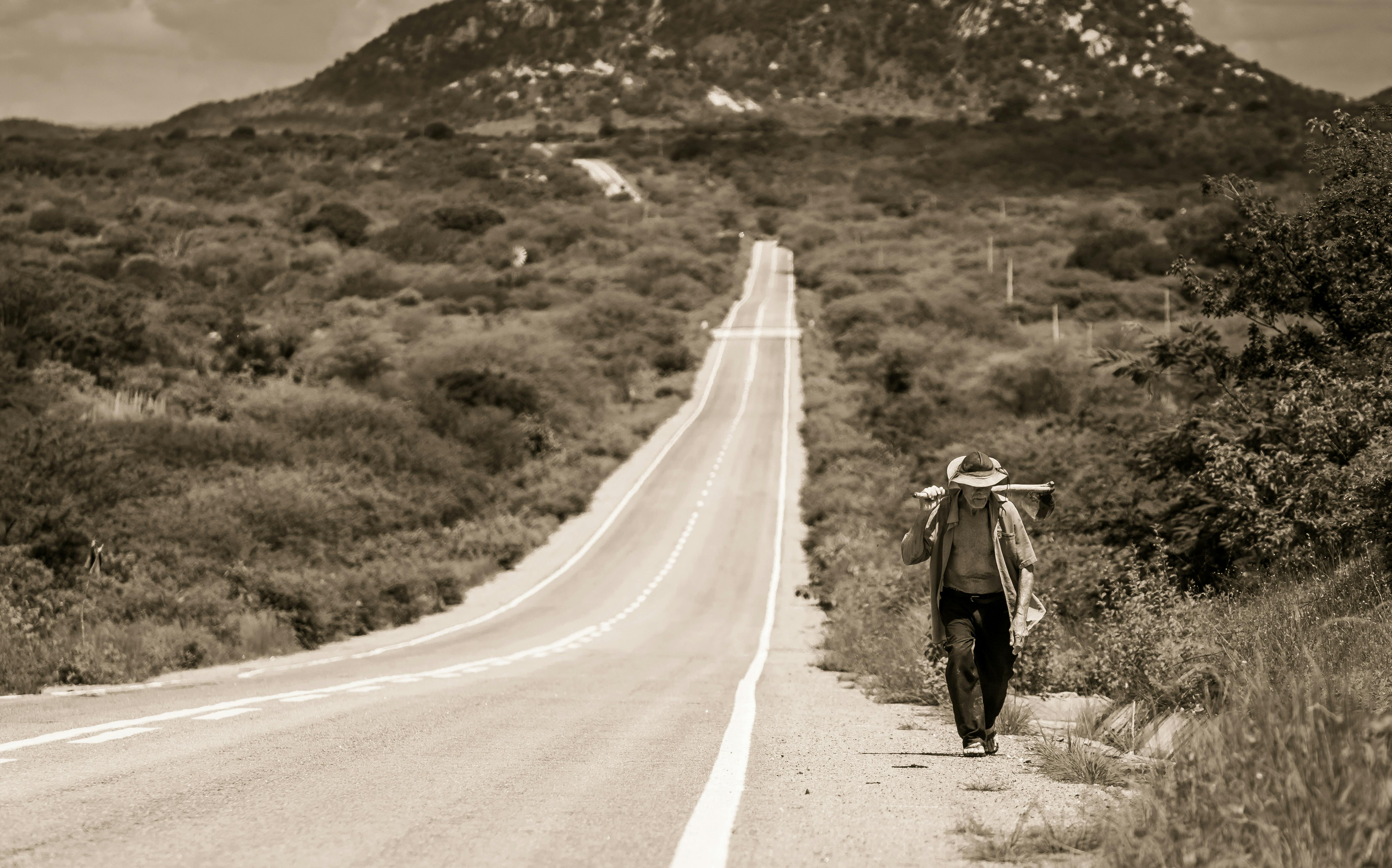 Grayscale Photo of Man Walking on Road · Free Stock Photo