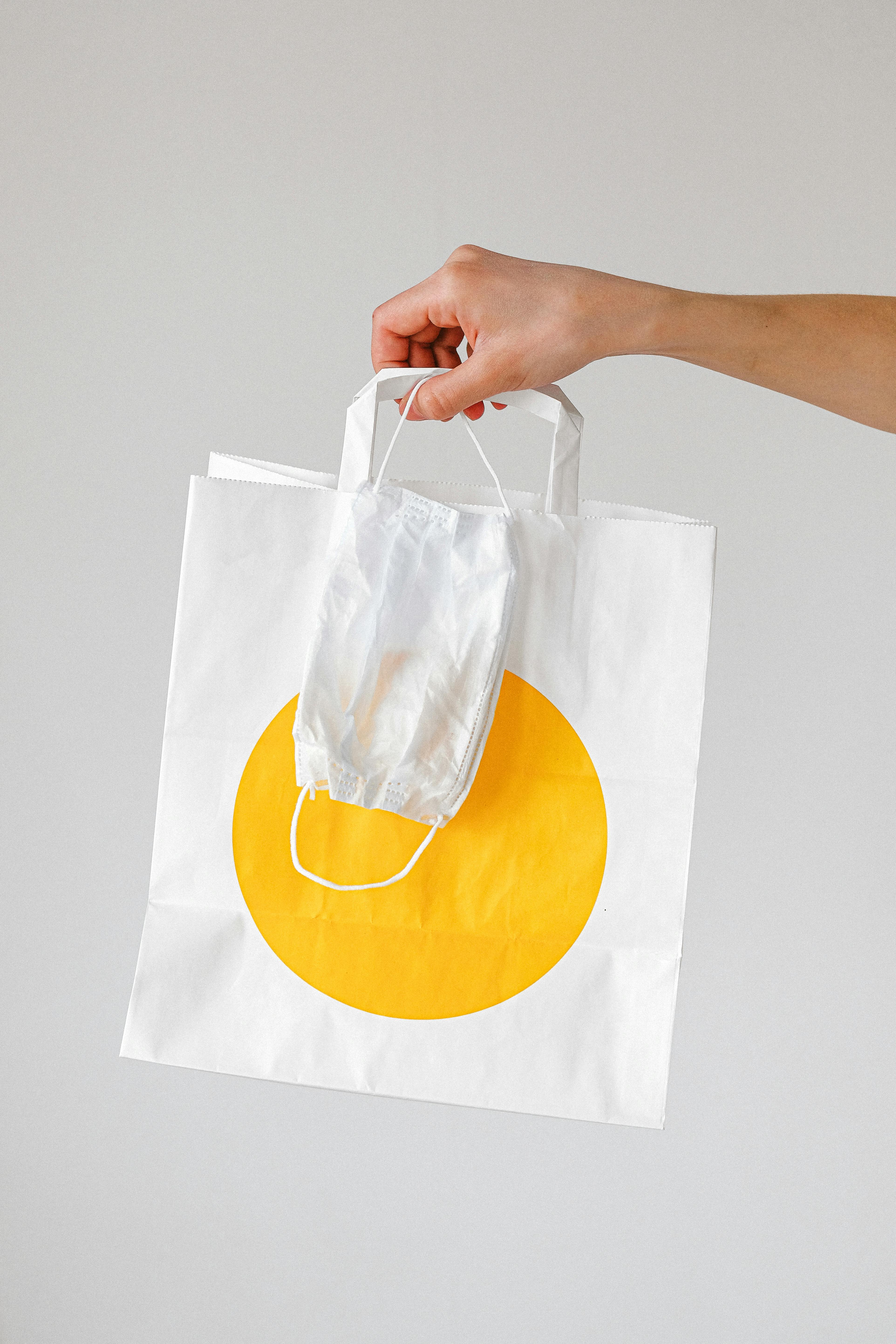 Person Holding Paper Bag and Face Mask · Free Stock Photo