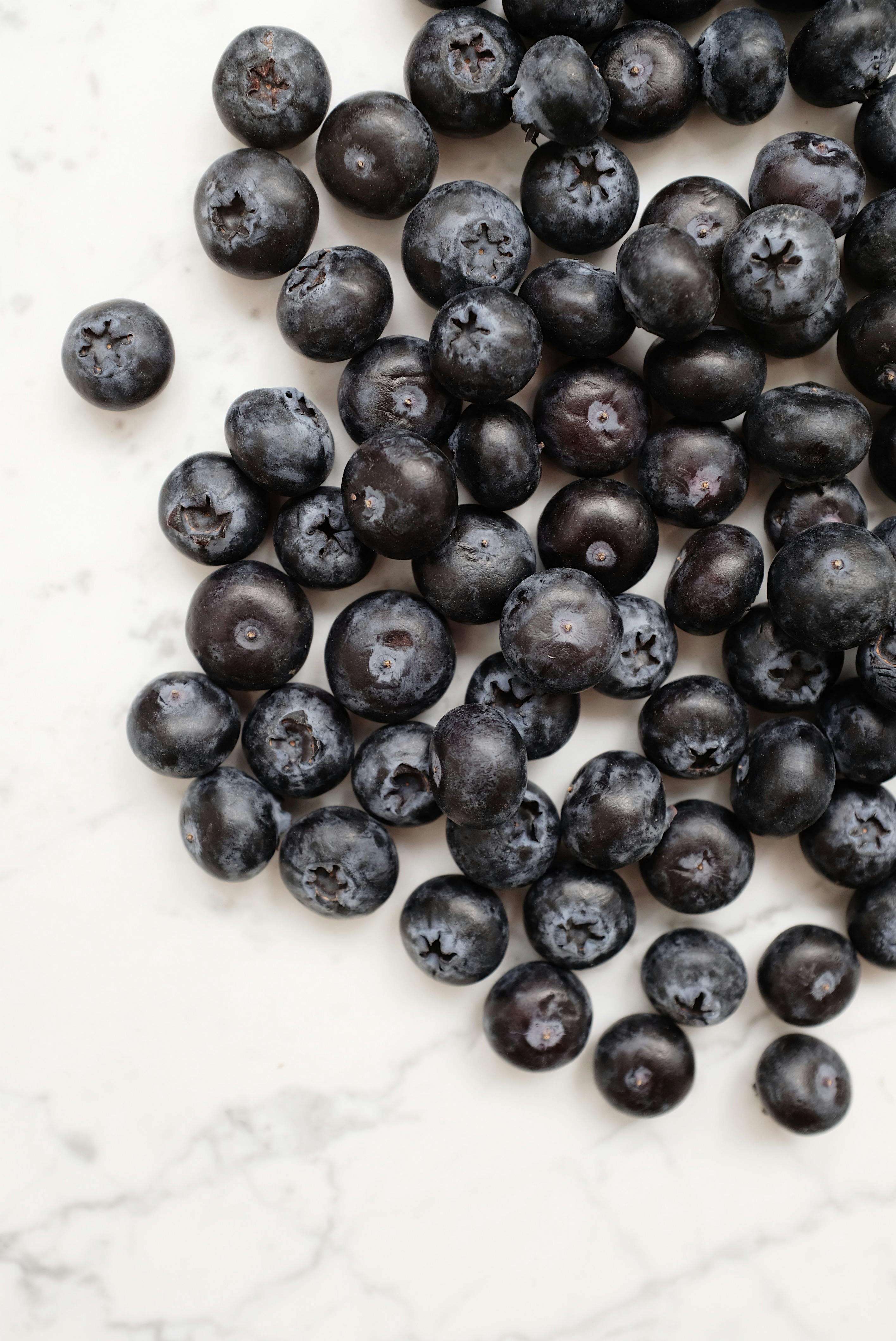 Black Round Fruits on White Surface · Free Stock Photo