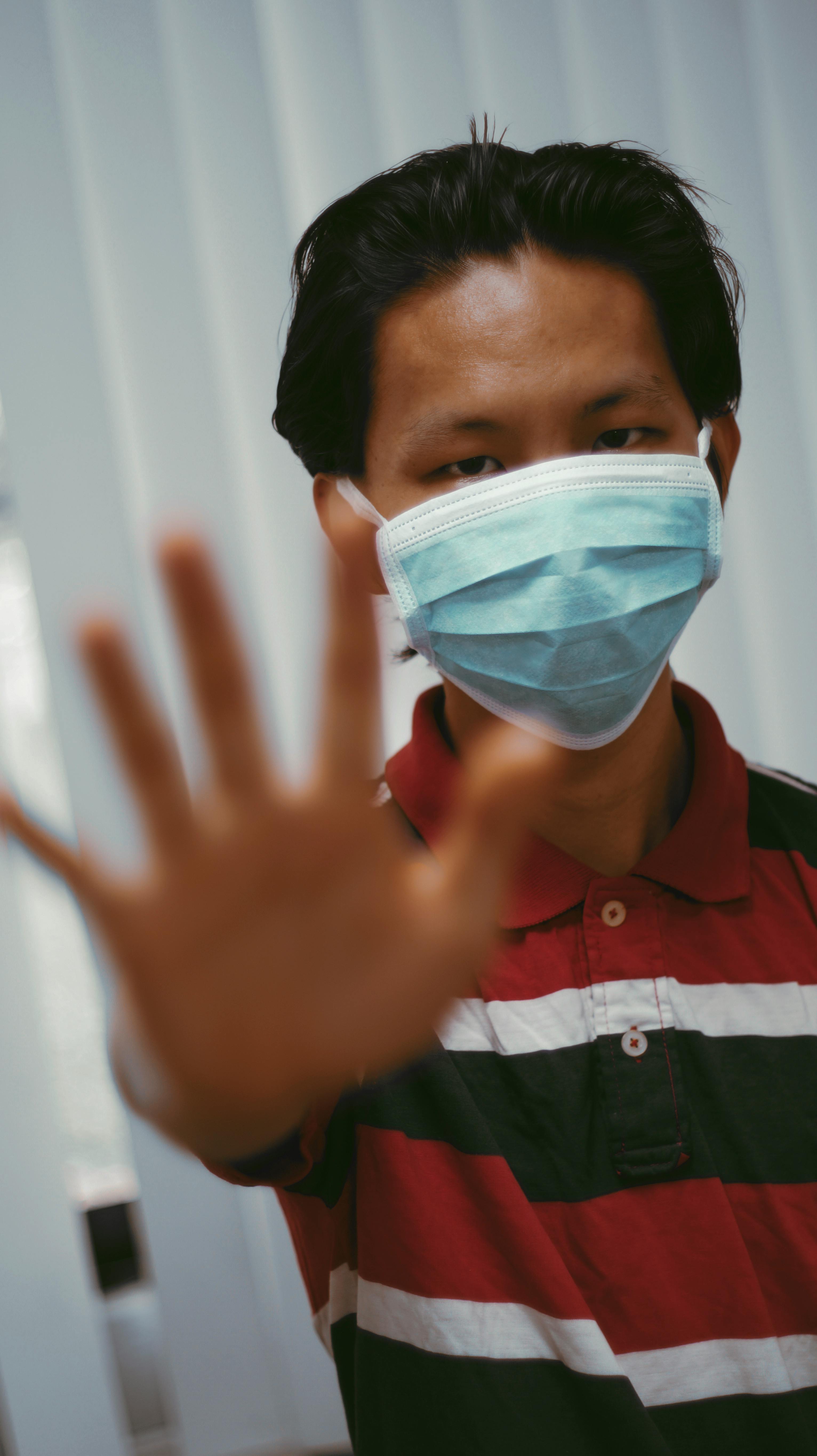 Person in White Protective Suit Sitting on Green Grass Field · Free ...