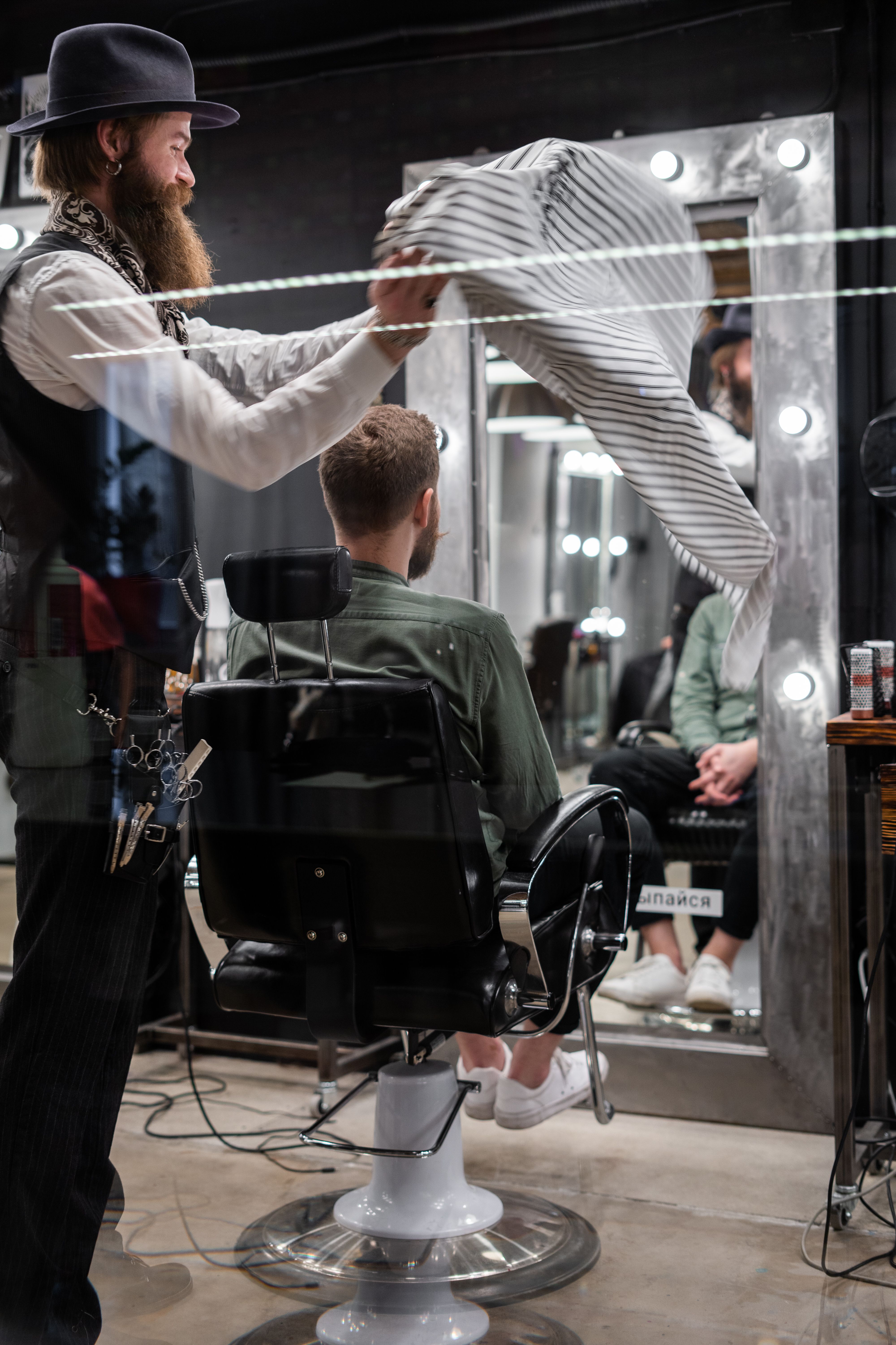 A Man Reading a Newspaper Inside a Barber Shop · Free Stock Photo