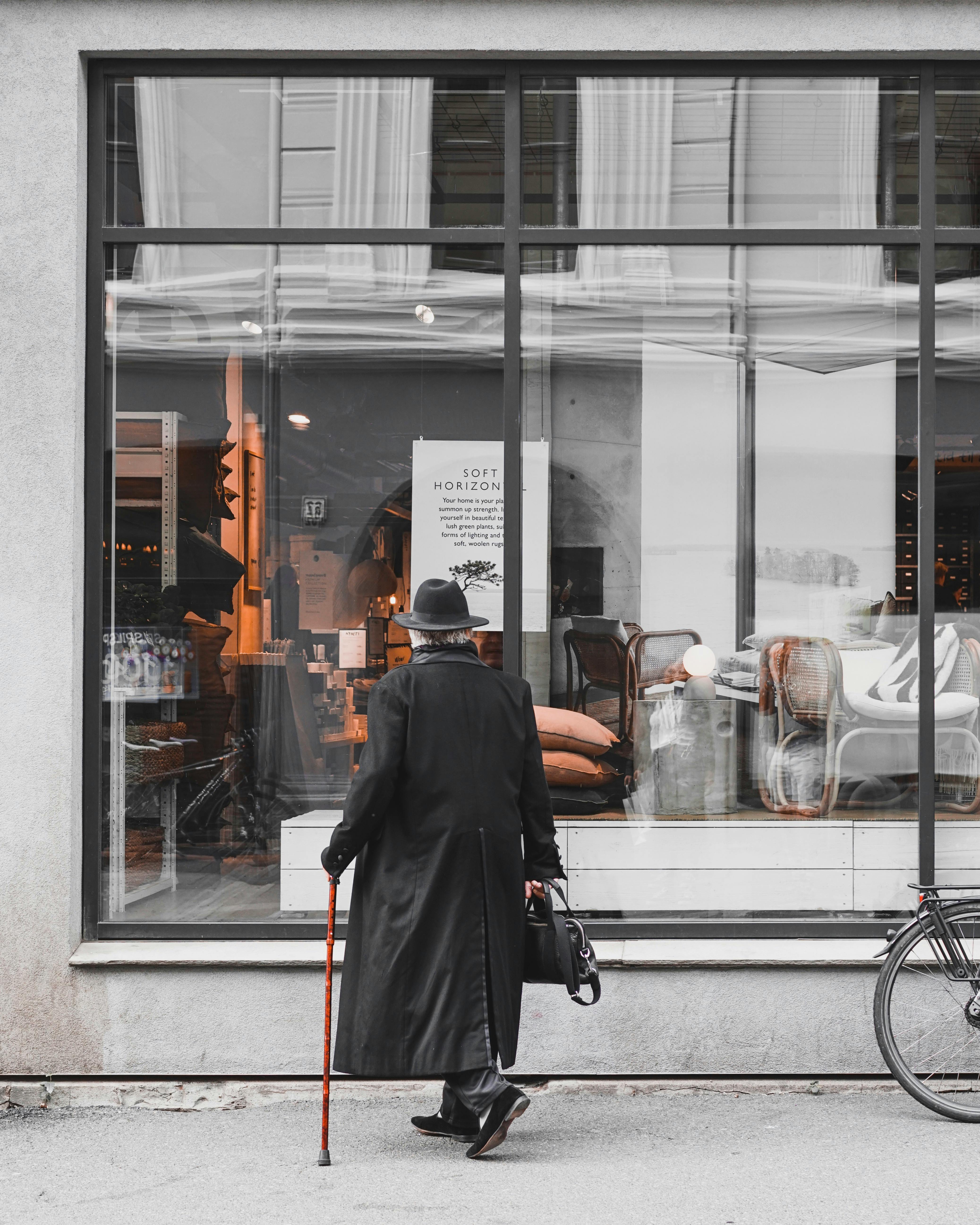 Man In Black Coat Standing In Front Of Glass Window · Free Stock Photo