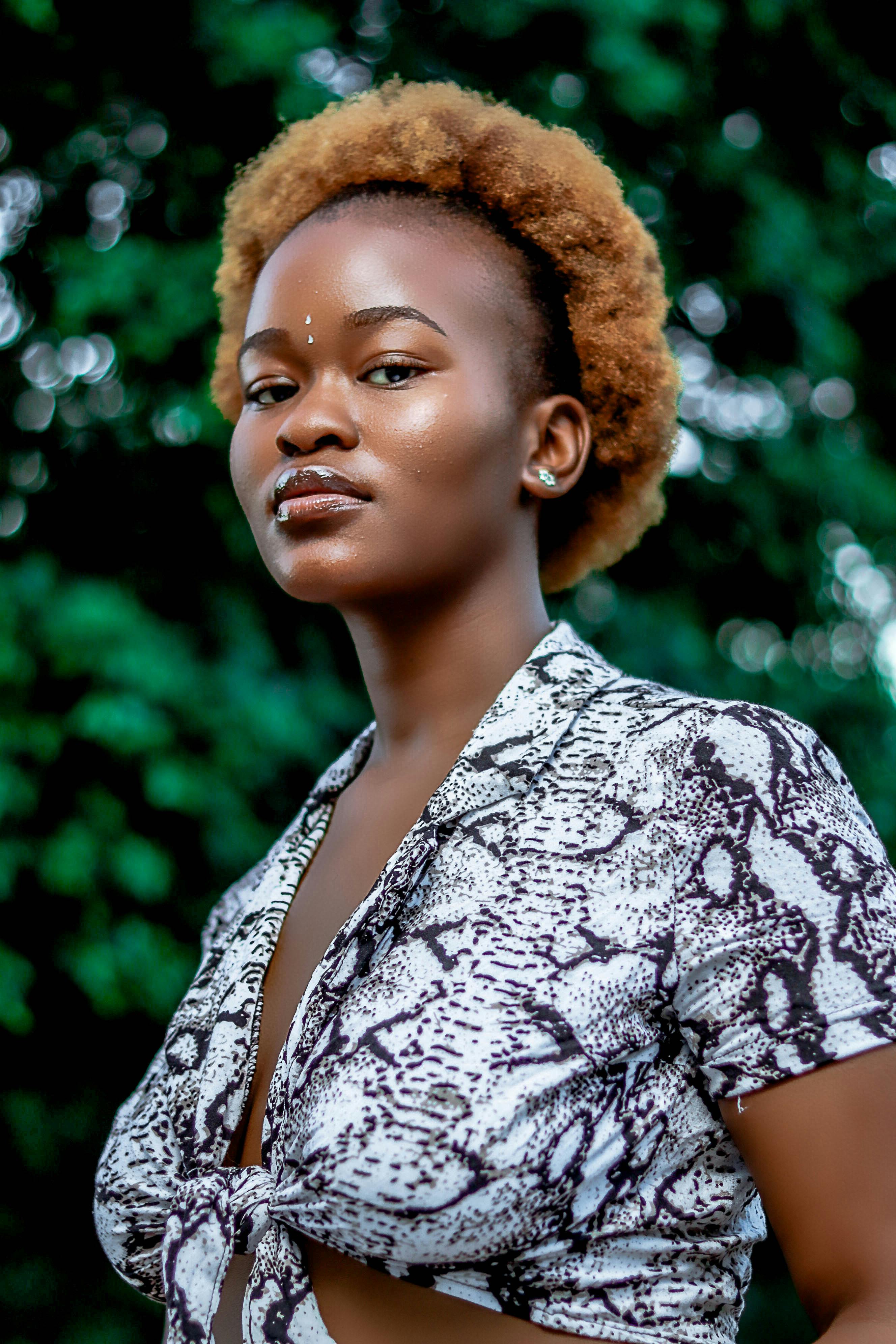 Stylish ethnic woman with Afro hairstyle recreating in summer garden ...