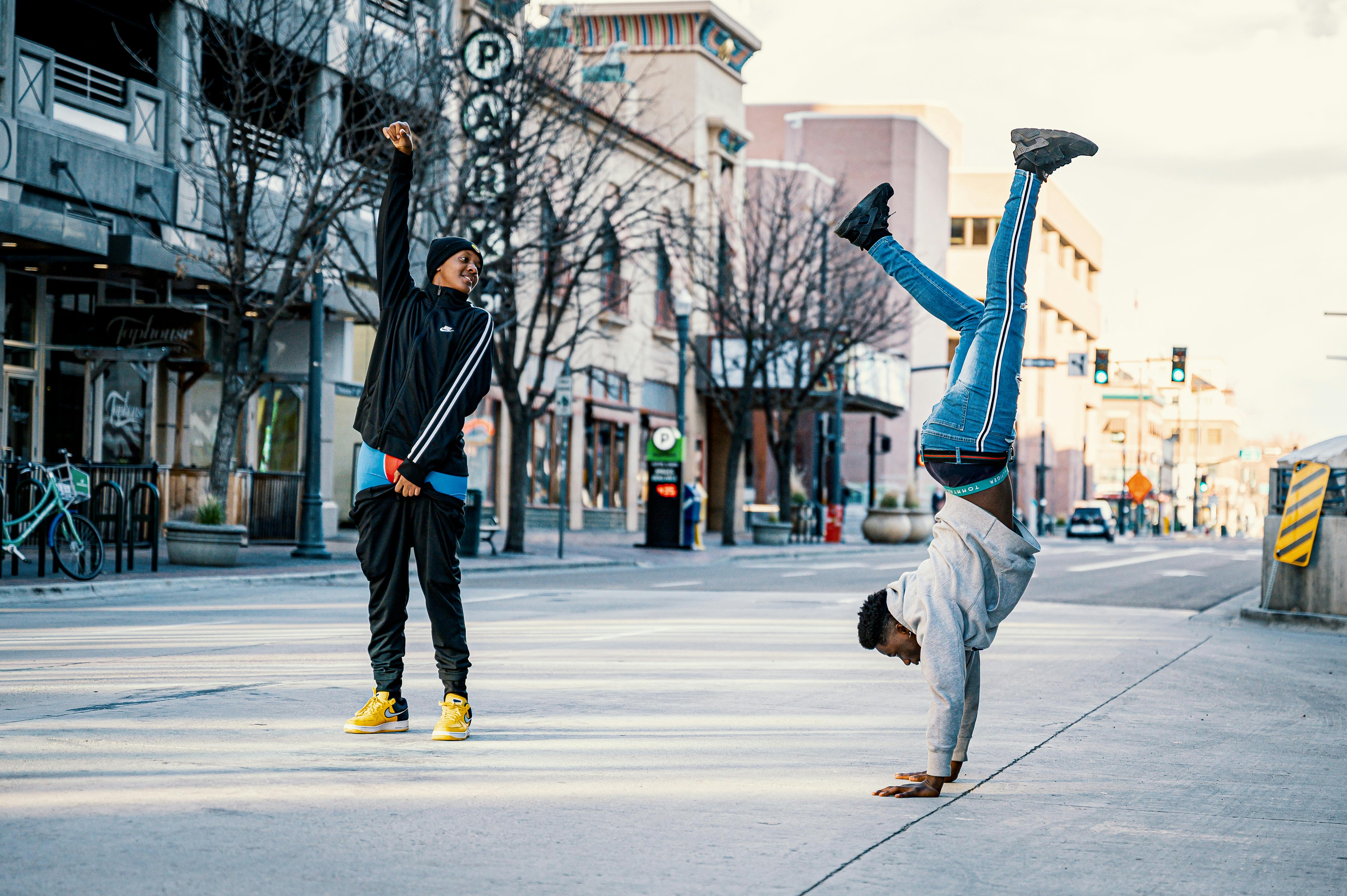 Male friends doing breakdance in center of street · Free Stock Photo