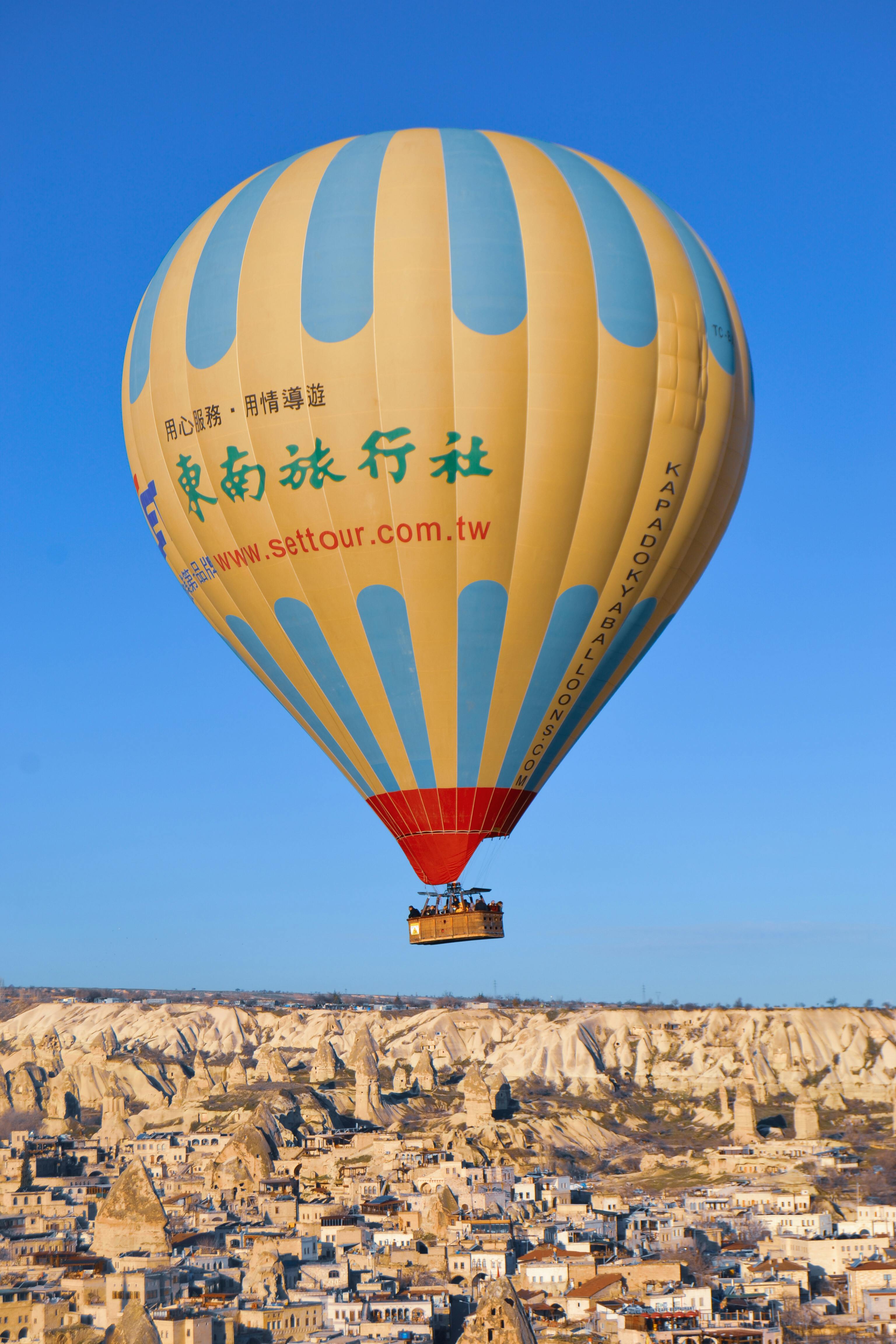 Hot air balloon flying over town · Free Stock Photo
