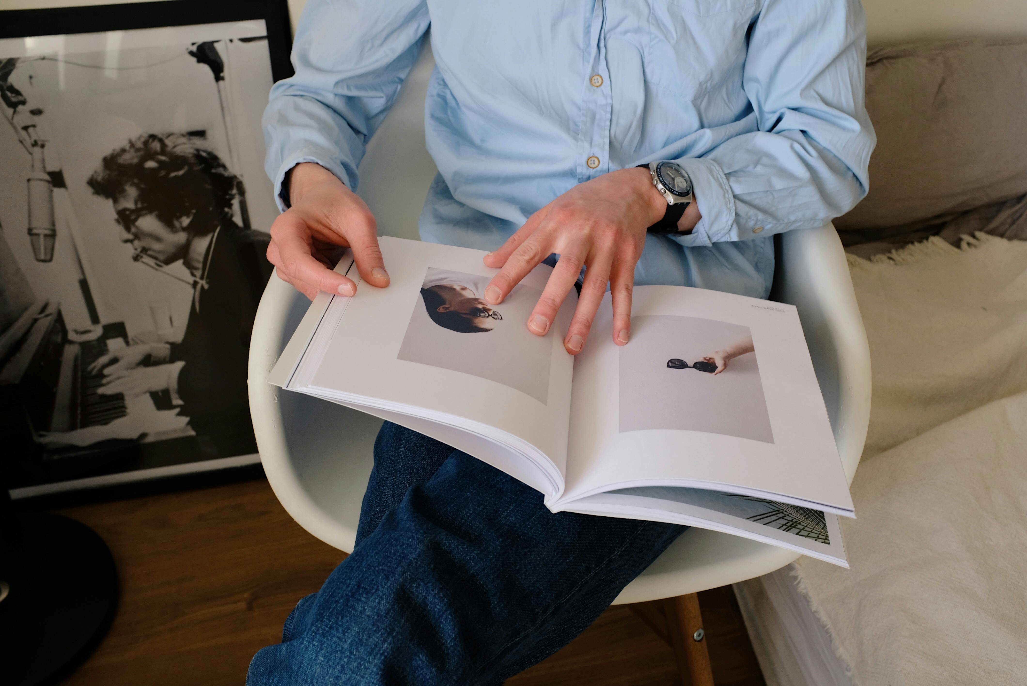 Unrecognizable man looking at photo in book at home · Free Stock Photo