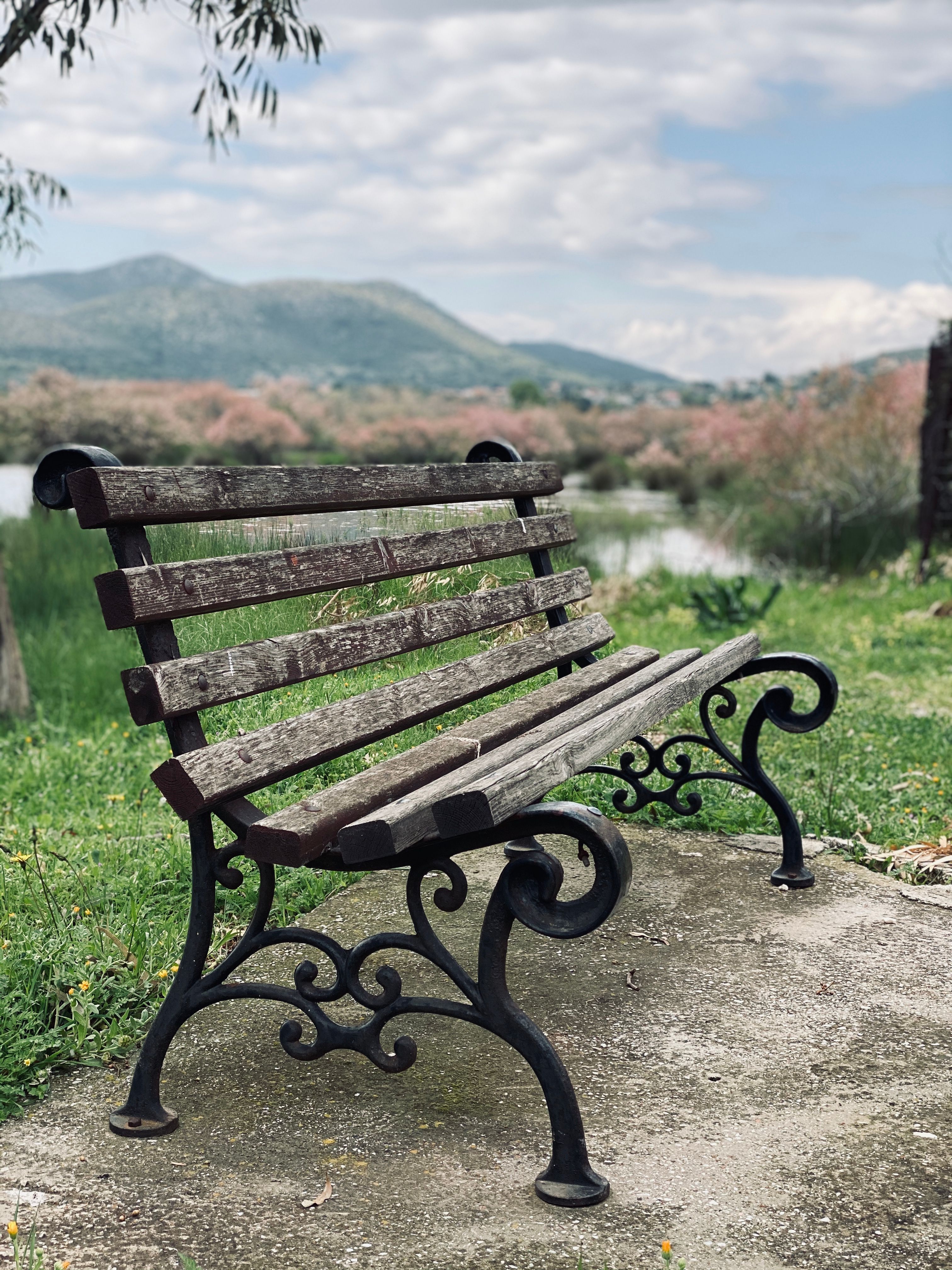 Old bench near field and mountains under cloudy sky · Free Stock Photo