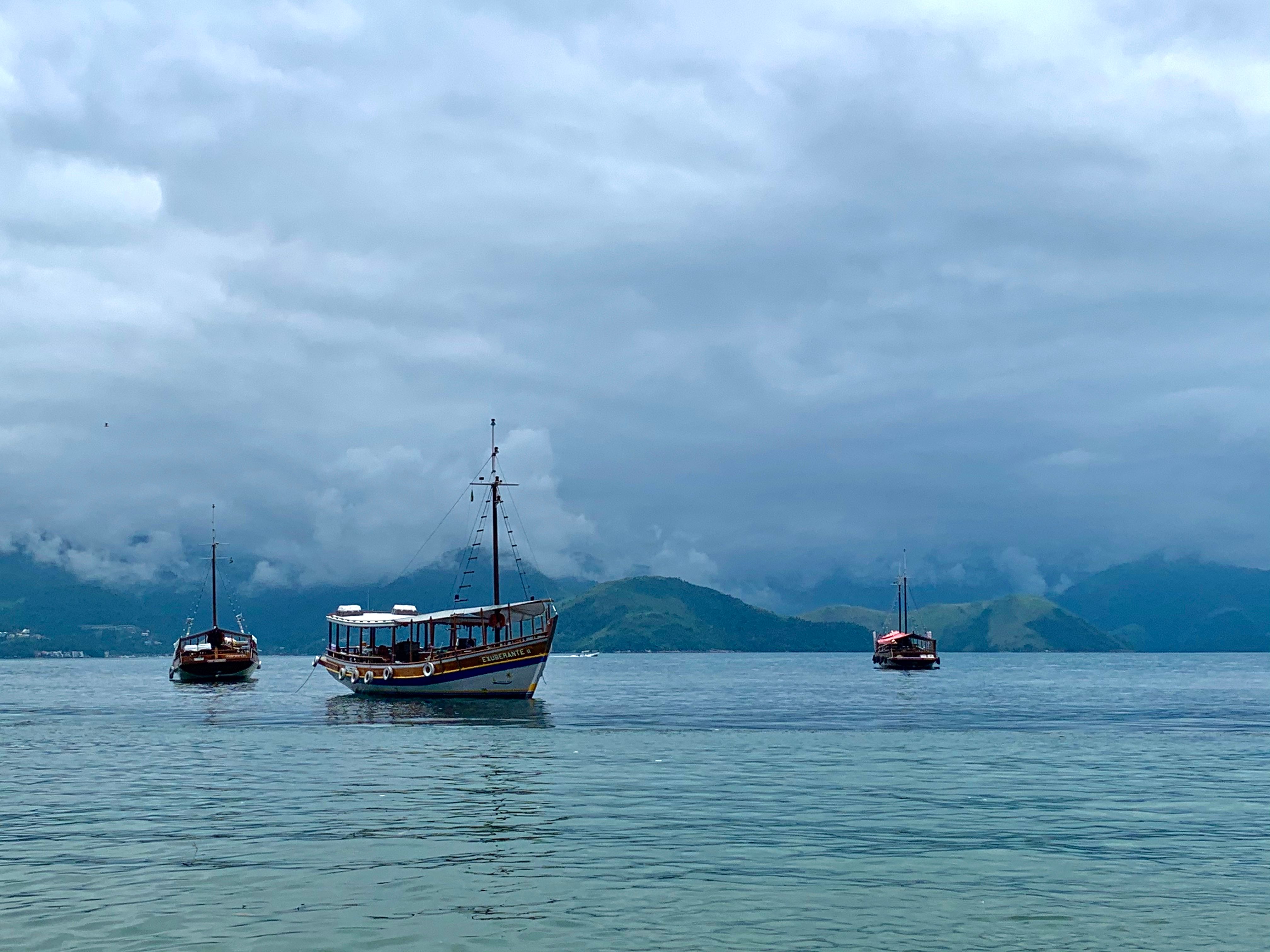 Road with vehicles over sea near moored boats · Free Stock Photo