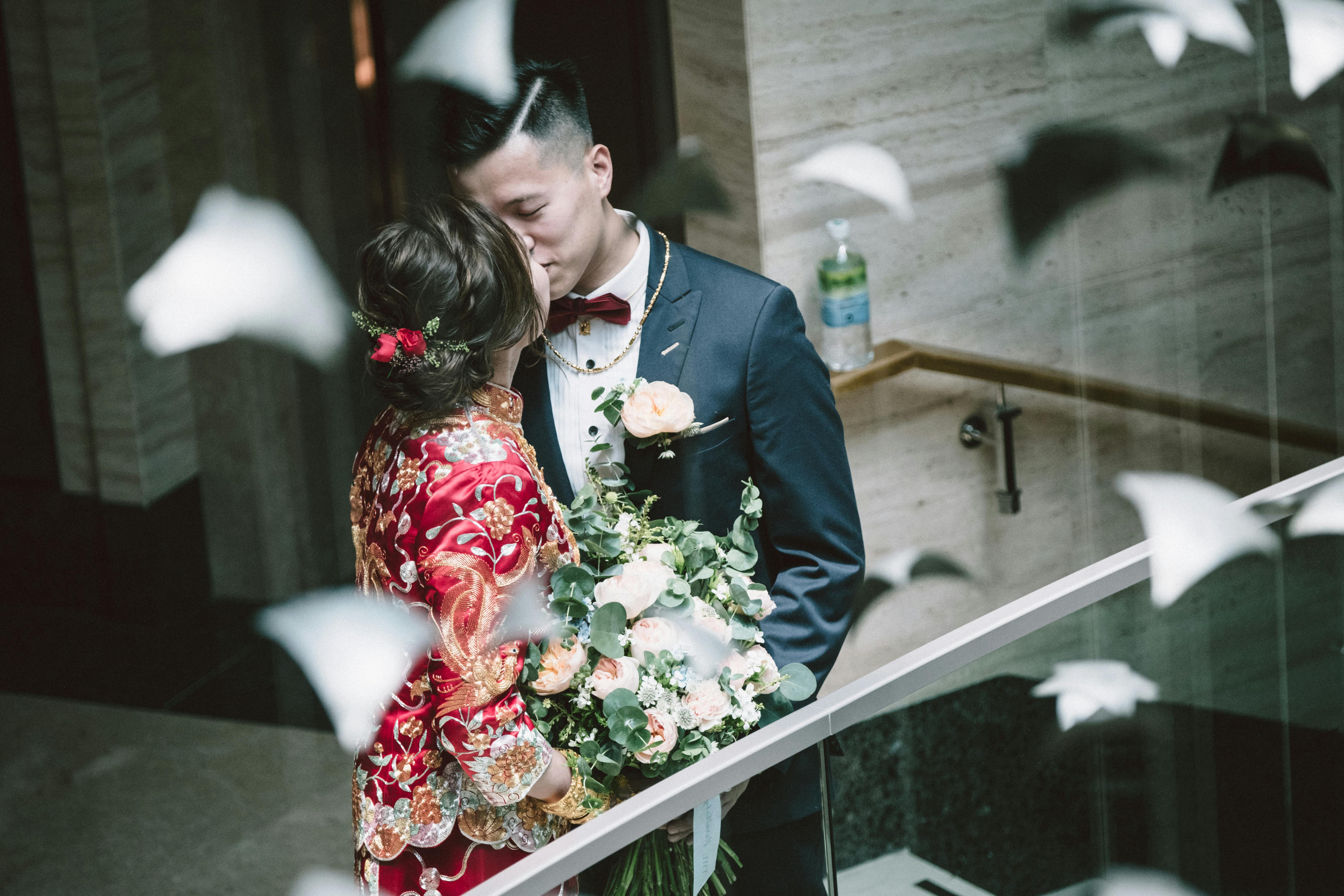 Asian newlywed couple kissing while celebrating wedding · Free Stock Photo