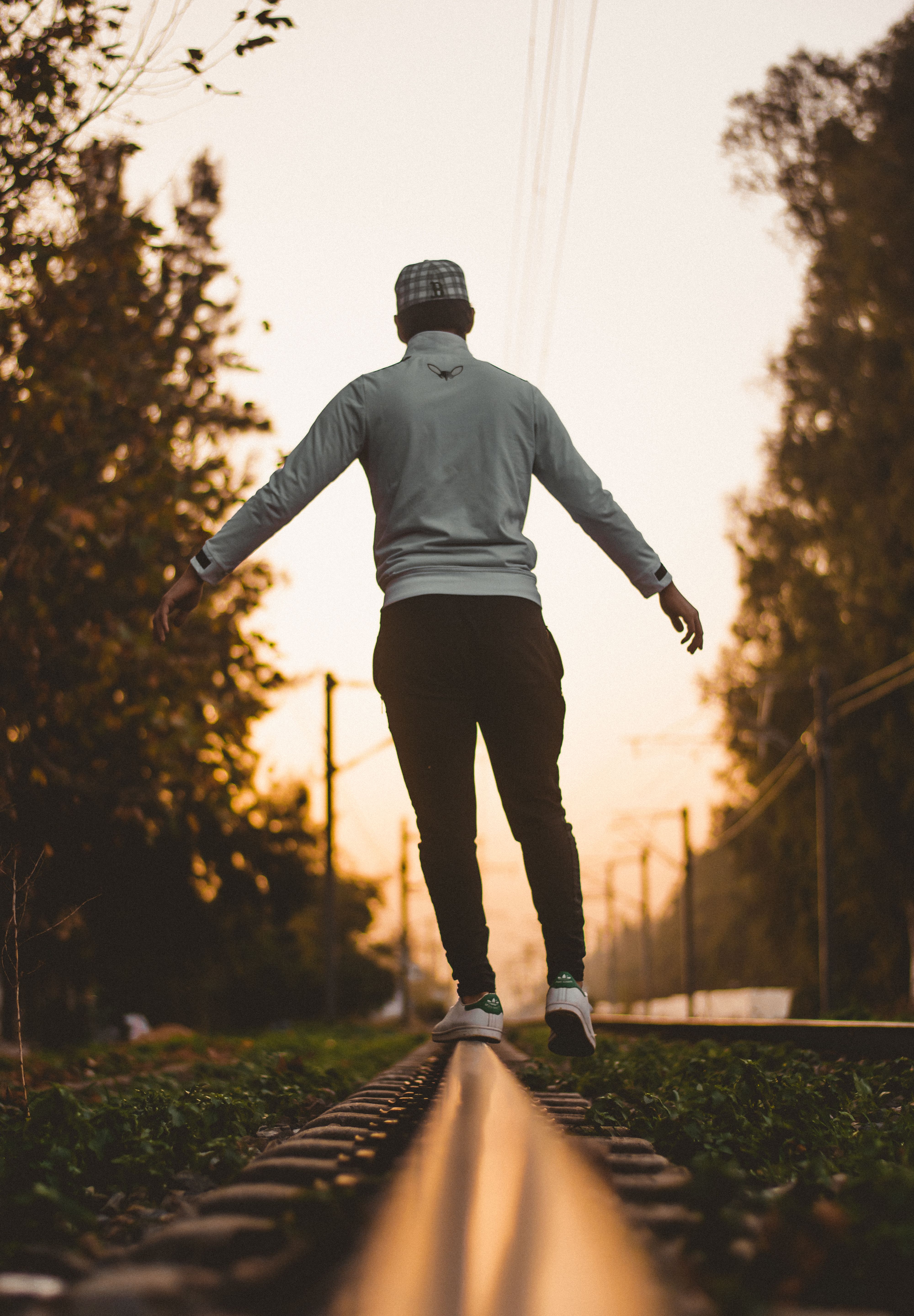 Photo Of Man Walking On Rail Tracks · Free Stock Photo