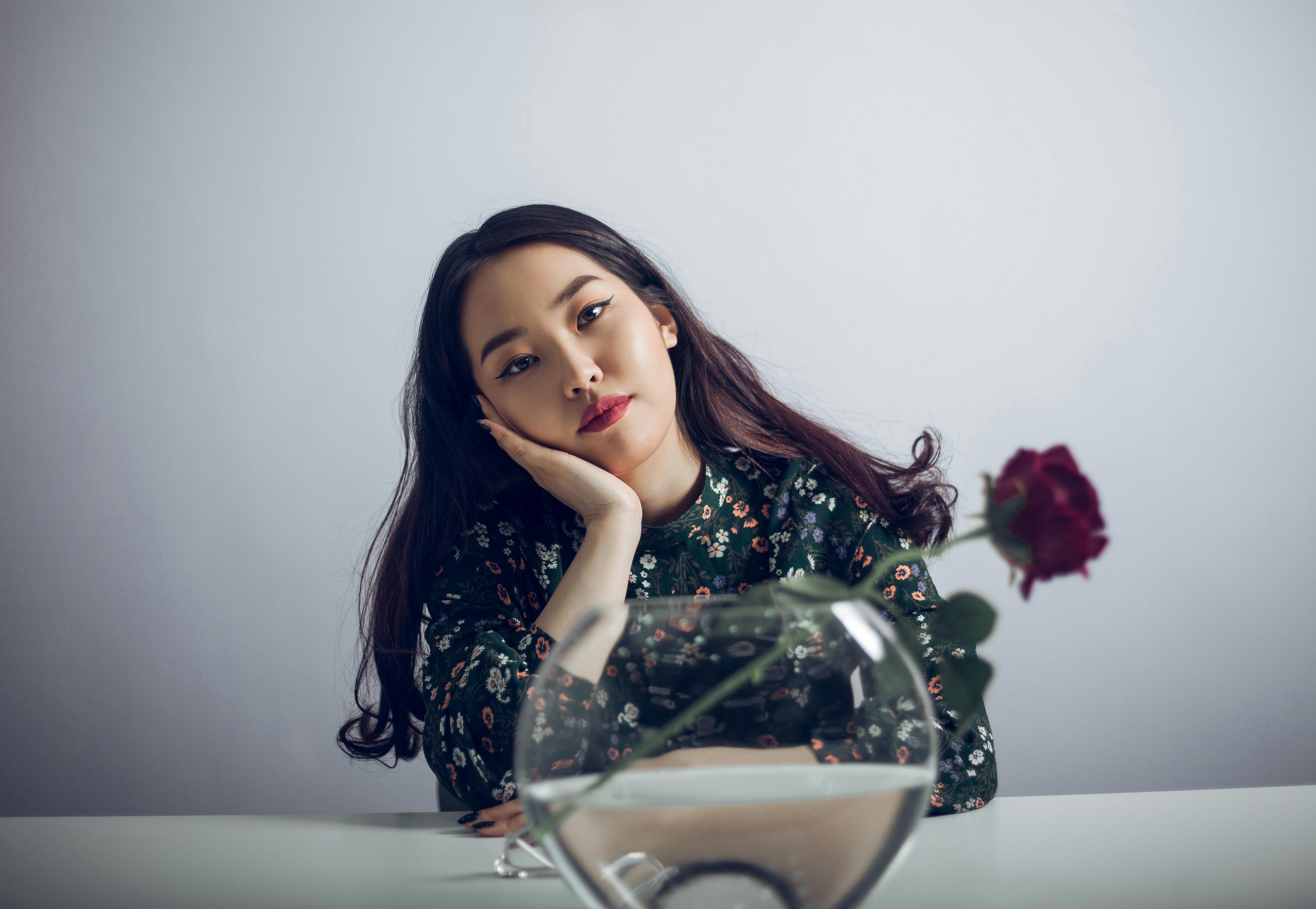 Young ethnic woman leaning on hand while sitting at table · Free Stock ...