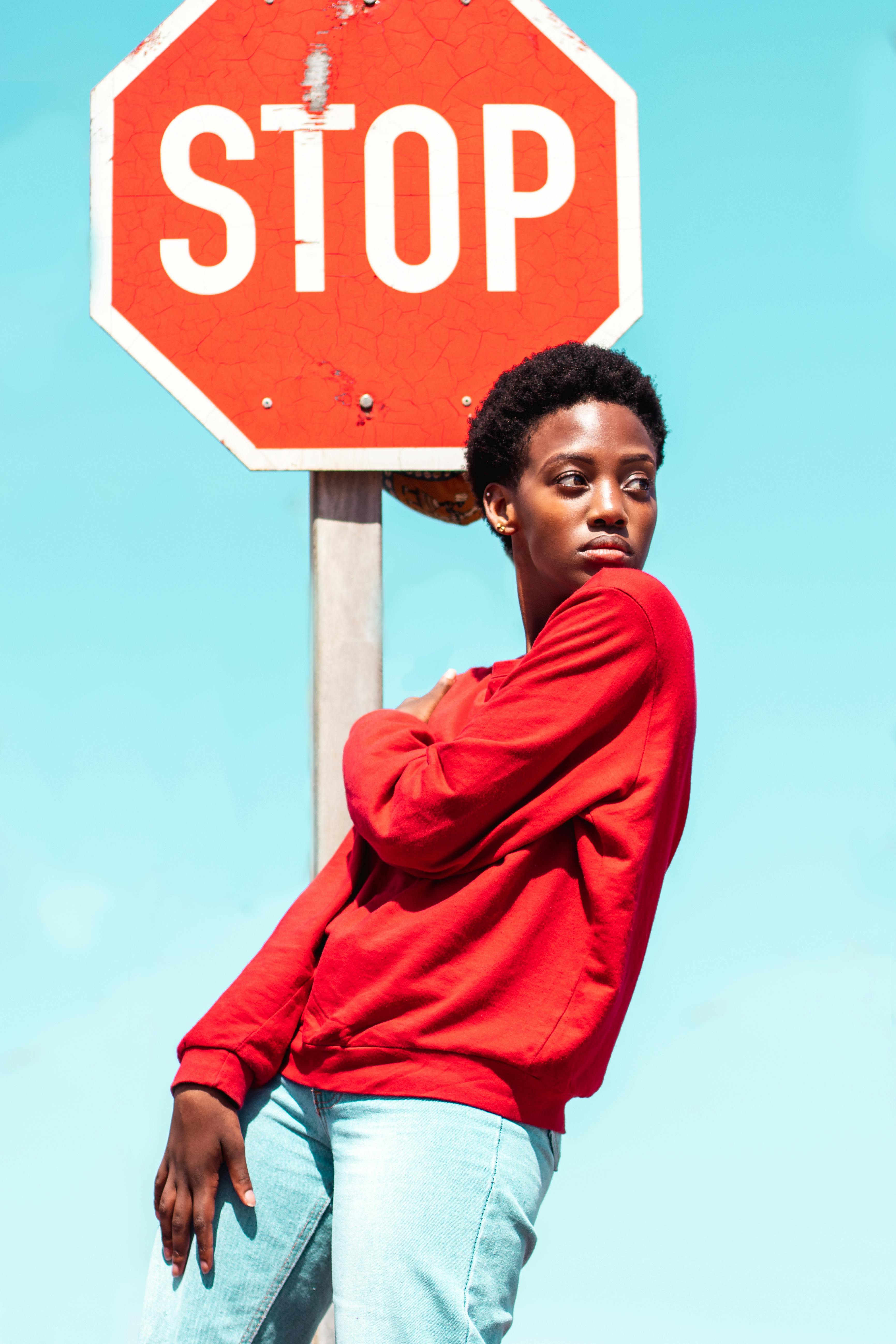 Photo of a Woman in a Red Sweatshirt Posing Near a Stop Sign · Free ...