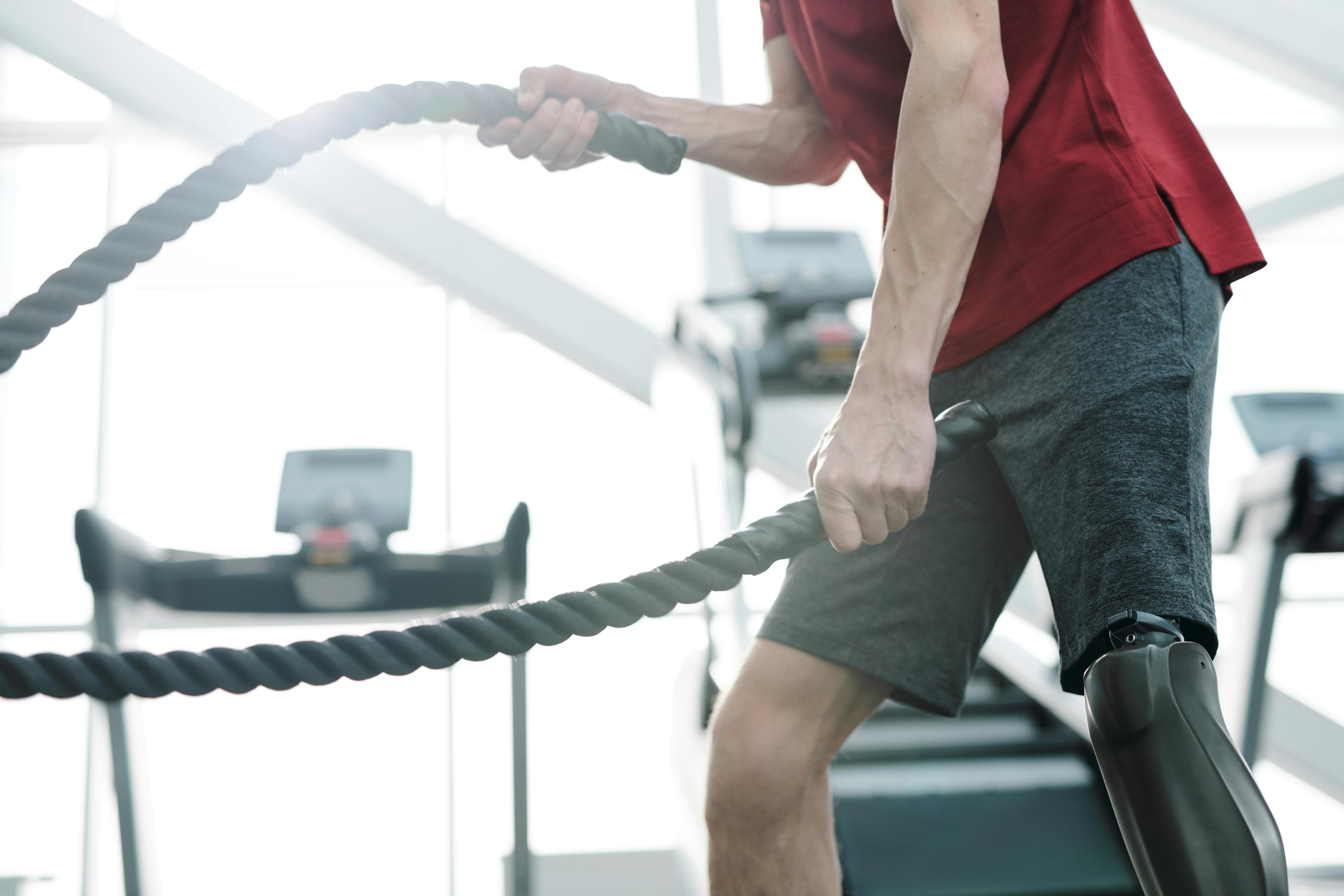 Man in Red T-shirt and Gray Shorts Holding Rope · Free Stock Photo