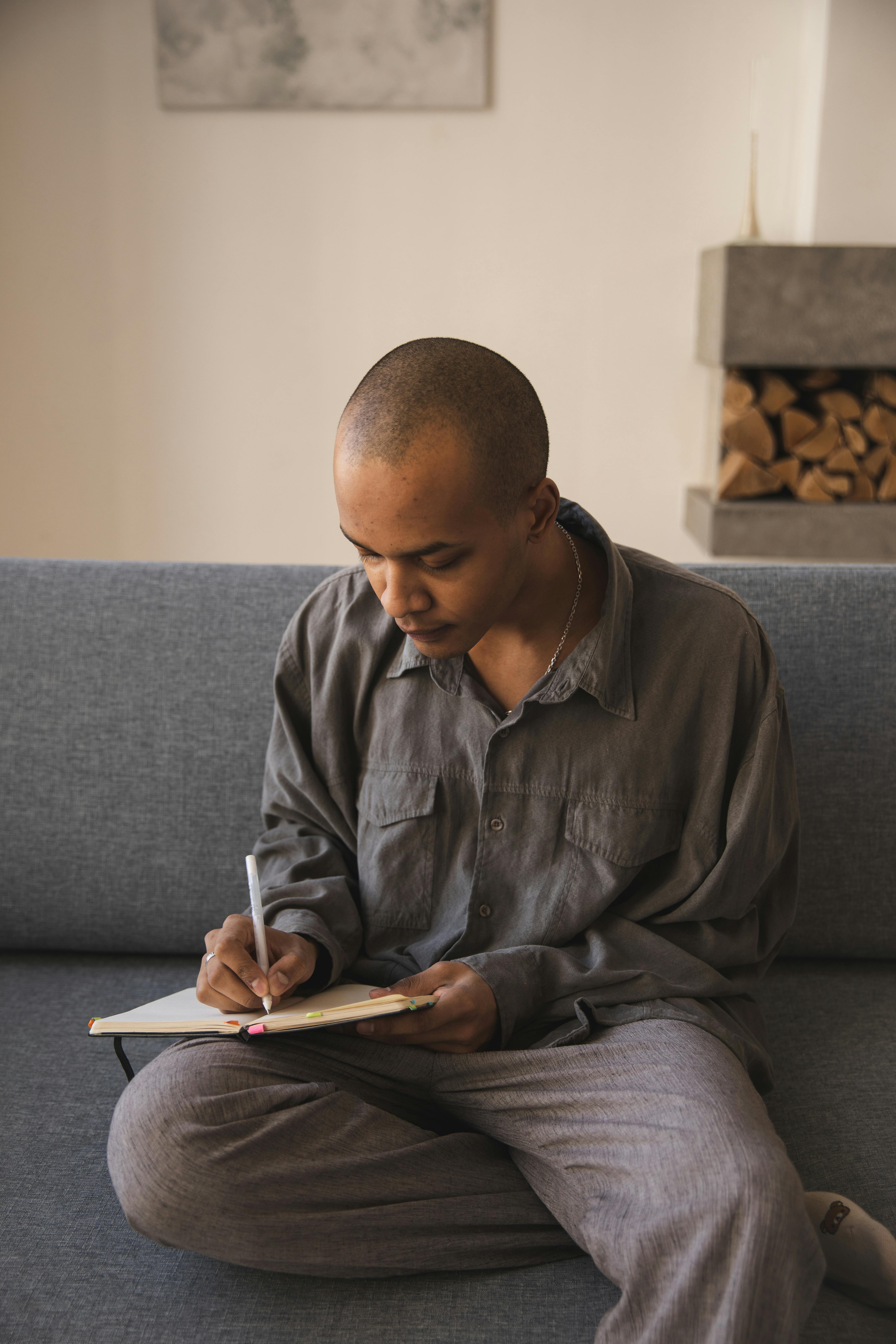 Thoughtful young ethnic man writing on notebook at home · Free Stock Photo Thoughtful young ethnic man writing on notebook at home · Free Stock Photo