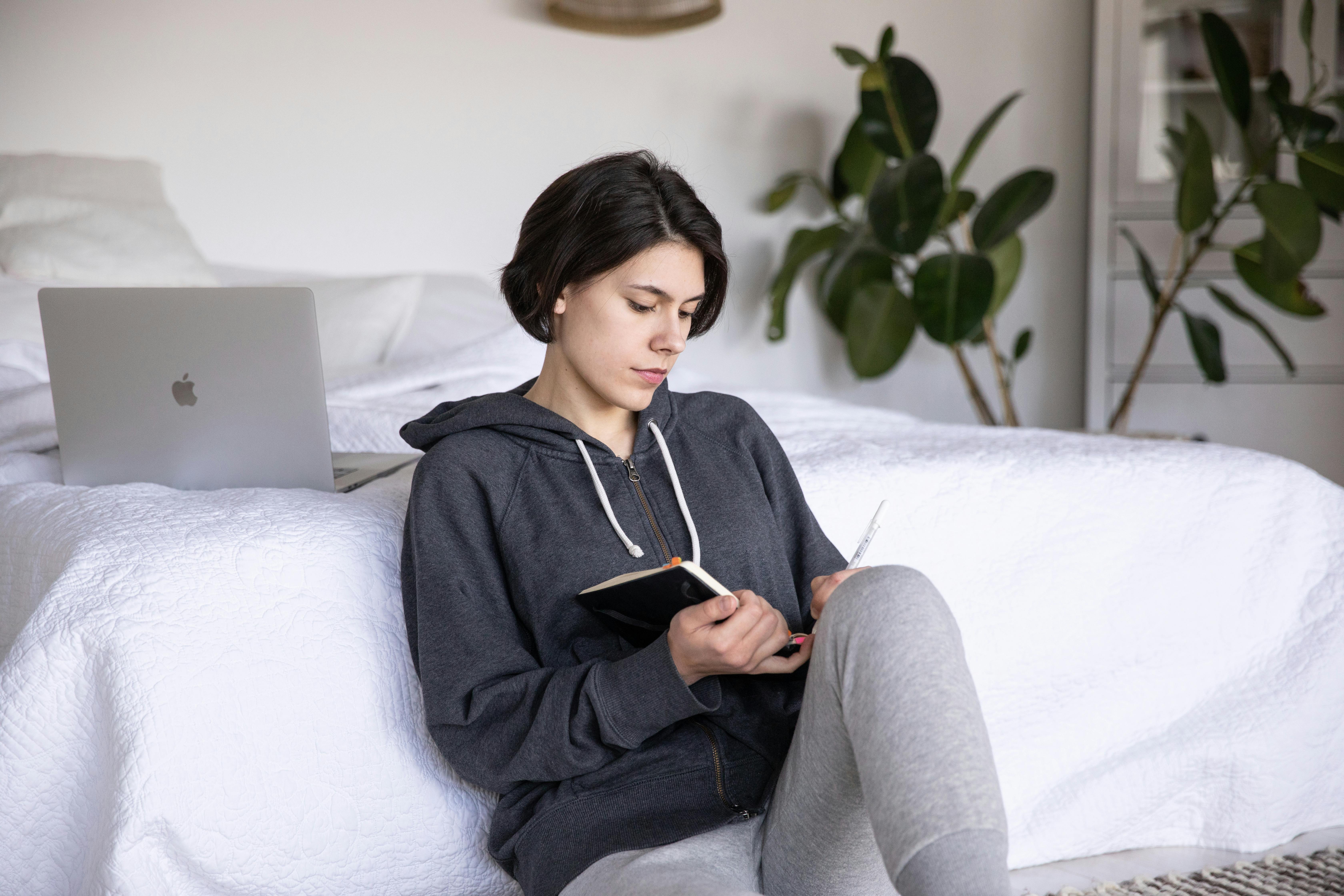 Smiling Woman Using Macbook While Sitting on Sofa · Free Stock Photo
