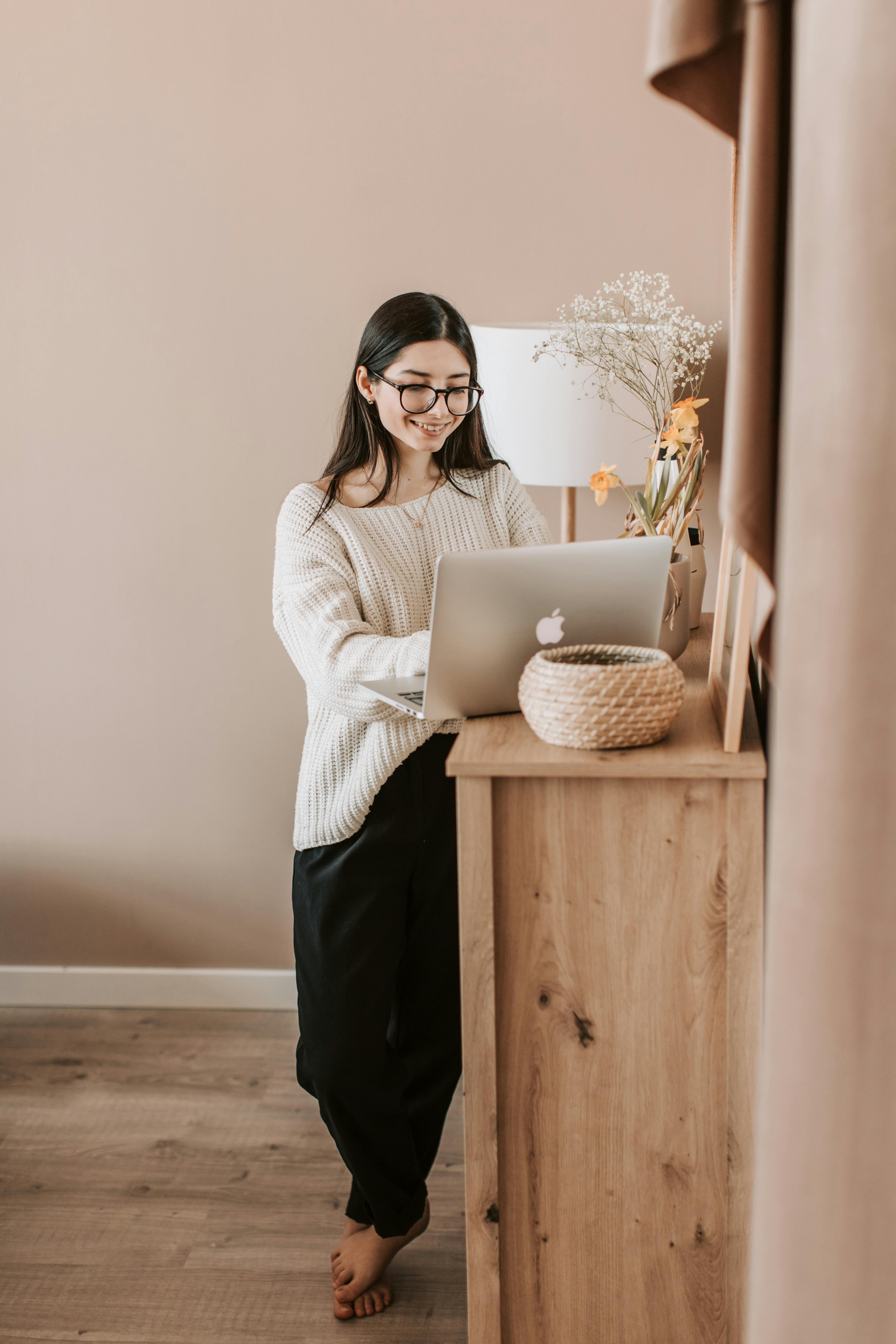 Woman Standing And Using Laptop · Free Stock Photo