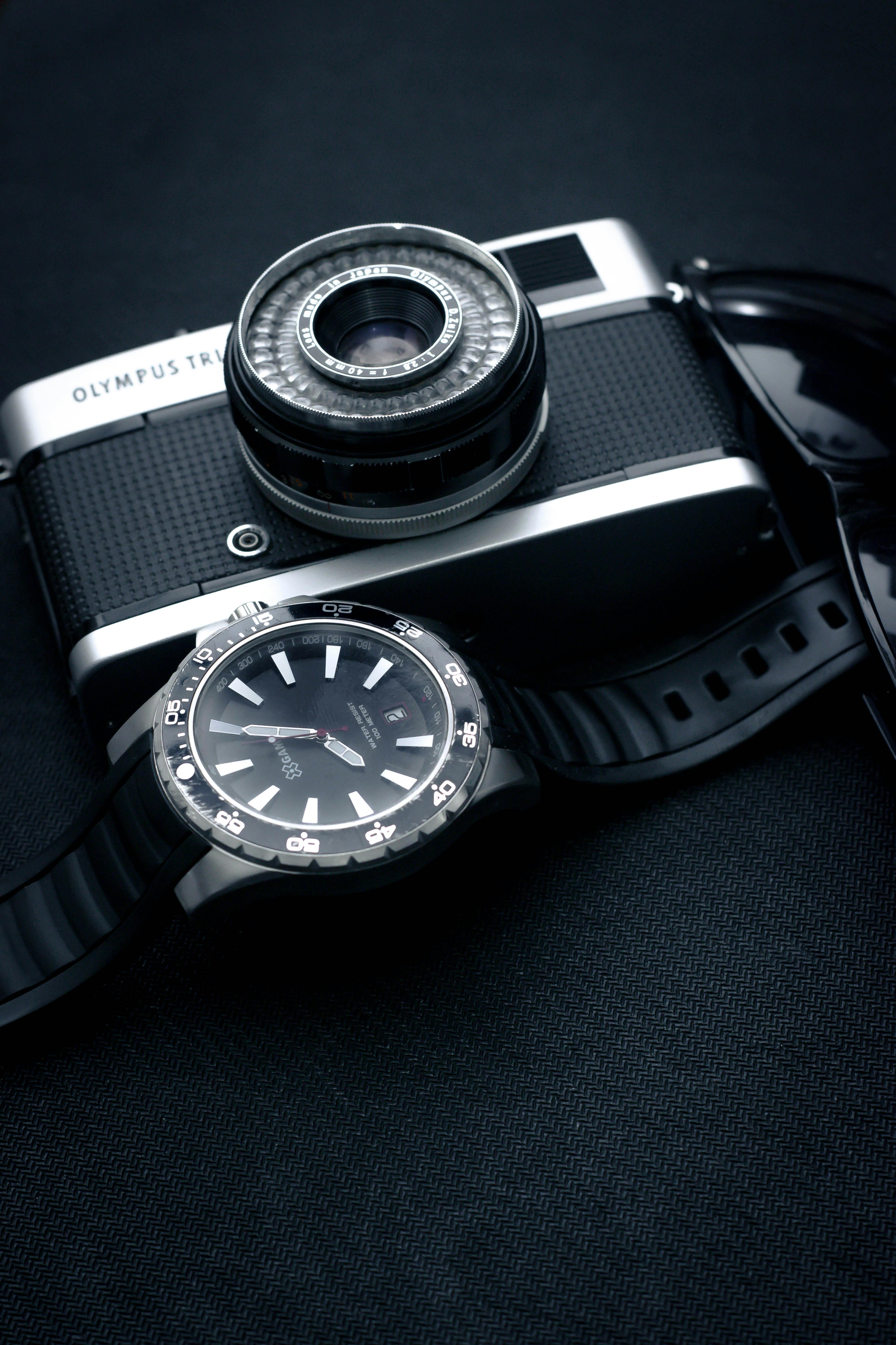 Close-Up Photo Of Watch Beside Camera · Free Stock Photo