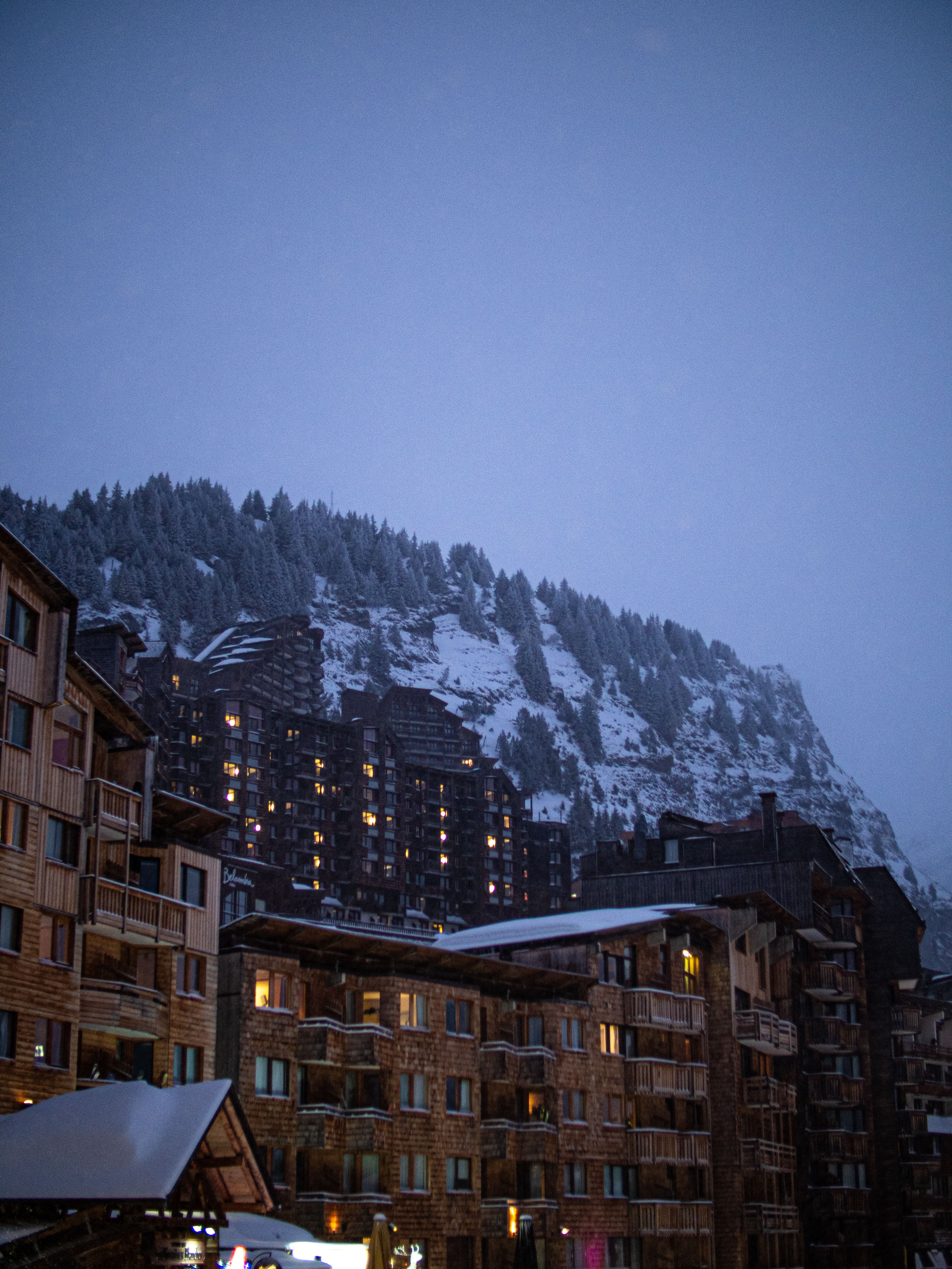 Brown Concrete Building Near Snow Covered Mountain · Free Stock Photo