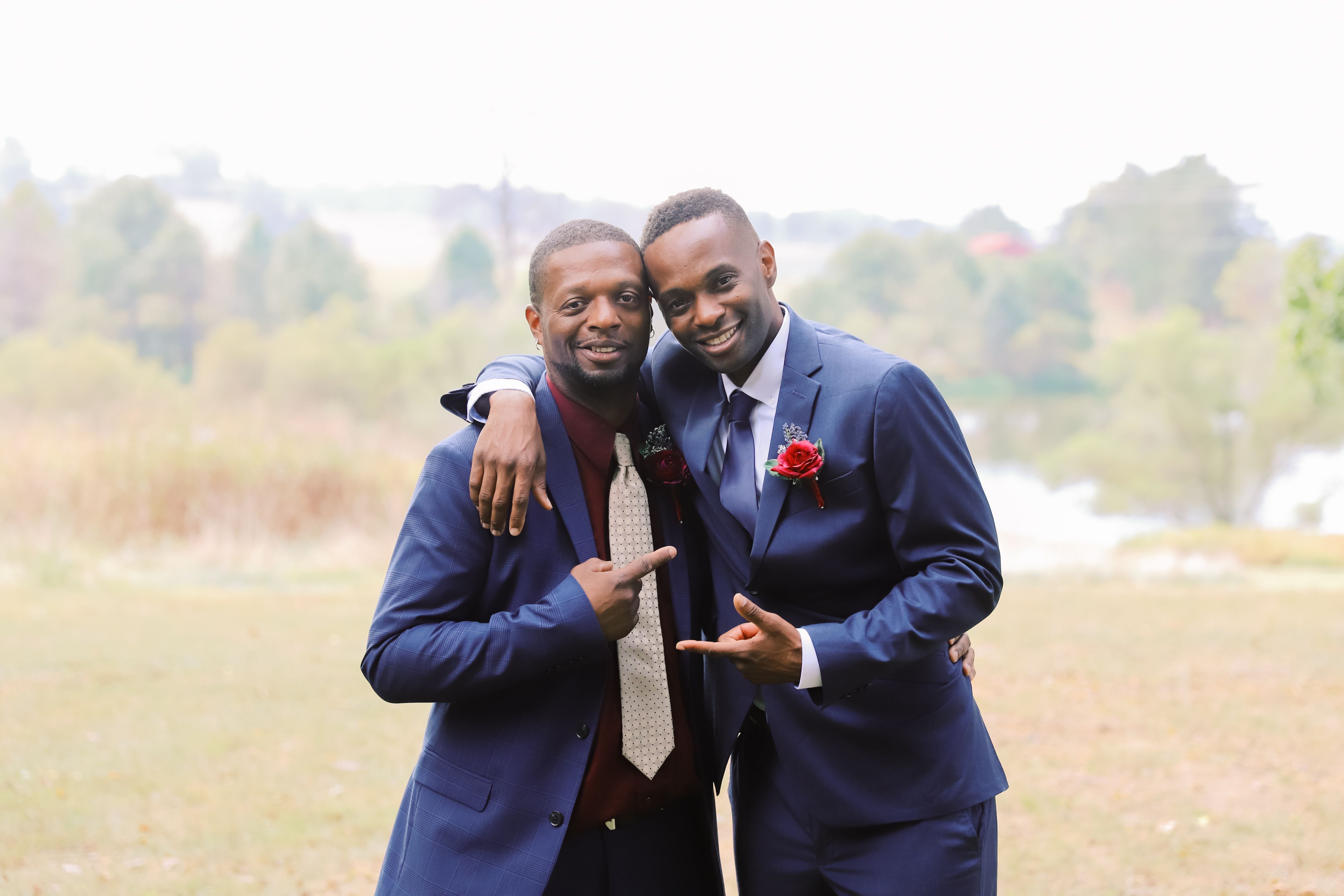 Black friends in suits pointing at each other · Free Stock Photo