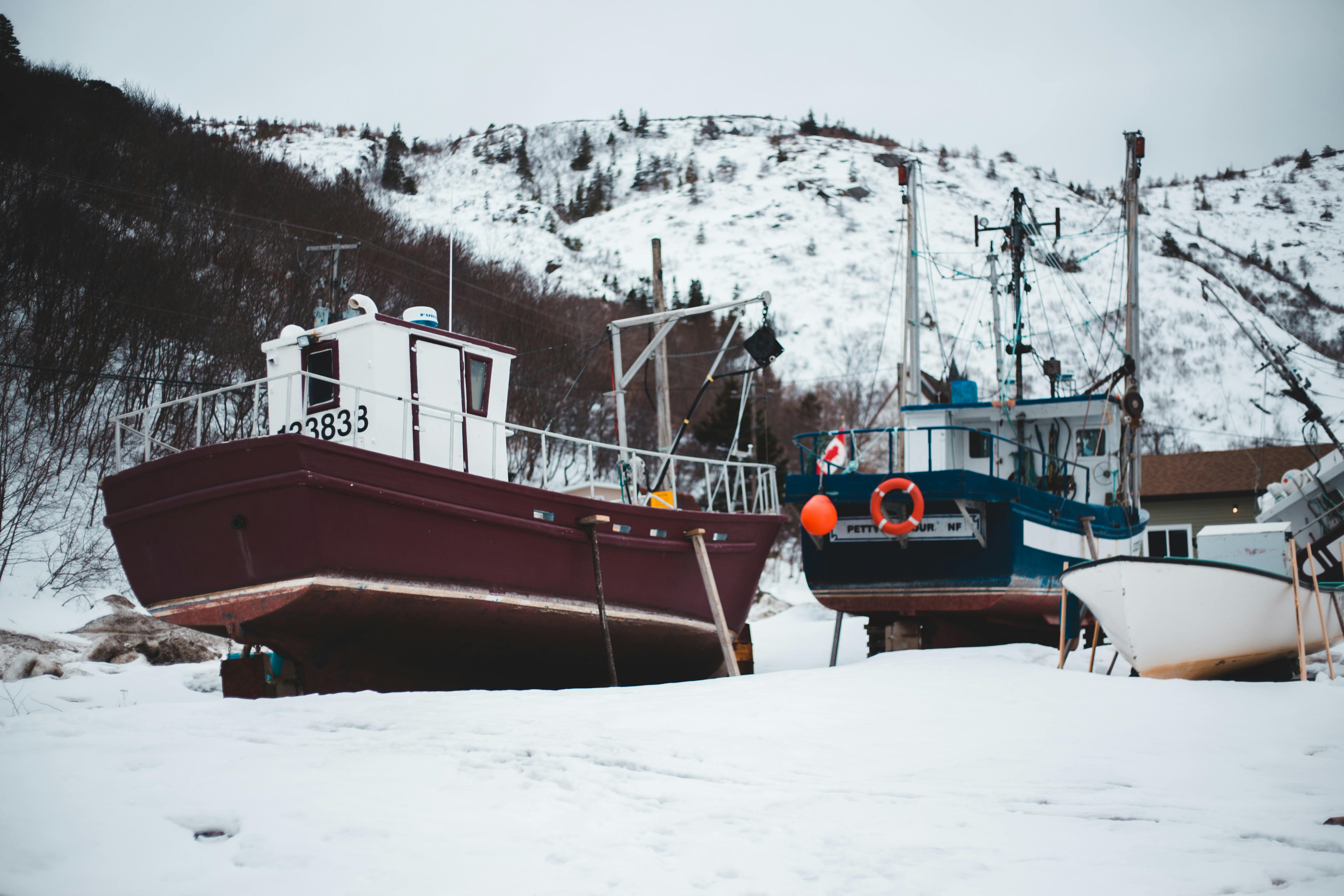 Boats on snowy coast with mountains · Free Stock Photo