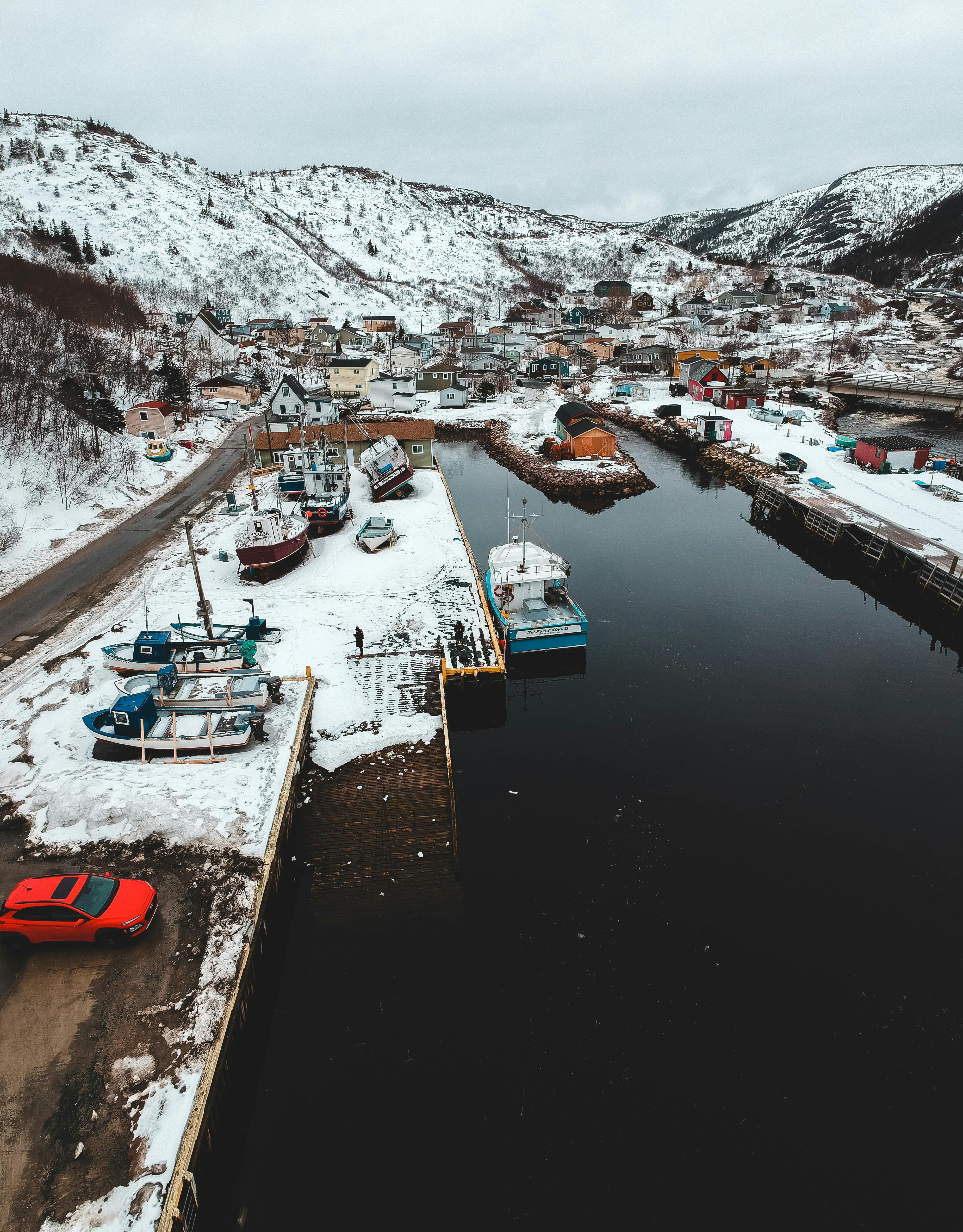 Peaceful dock with boats in snowy mountains · Free Stock Photo