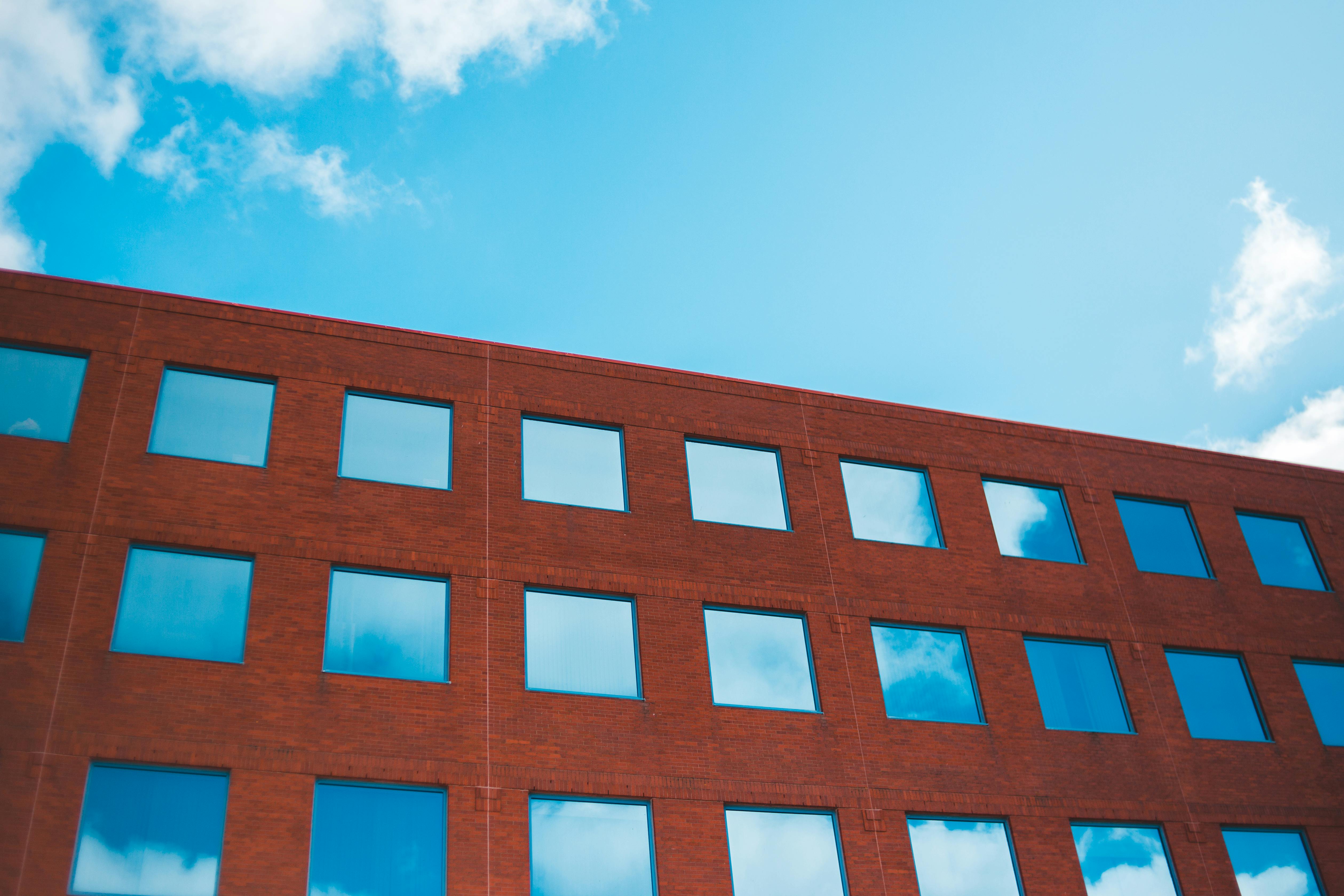 Contemporary wall with windows under blue sky · Free Stock Photo