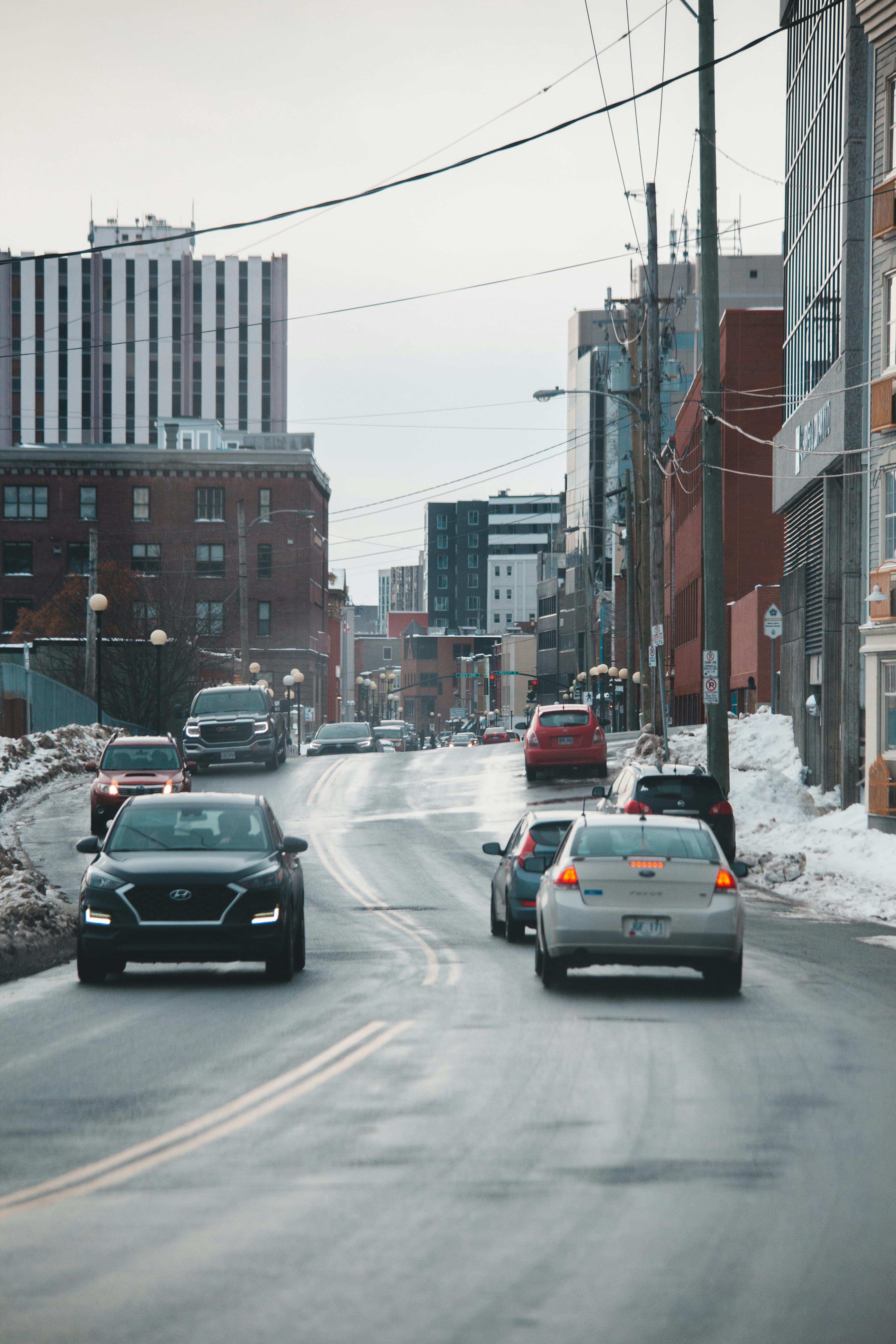 Cars on Road Between Buildings · Free Stock Photo