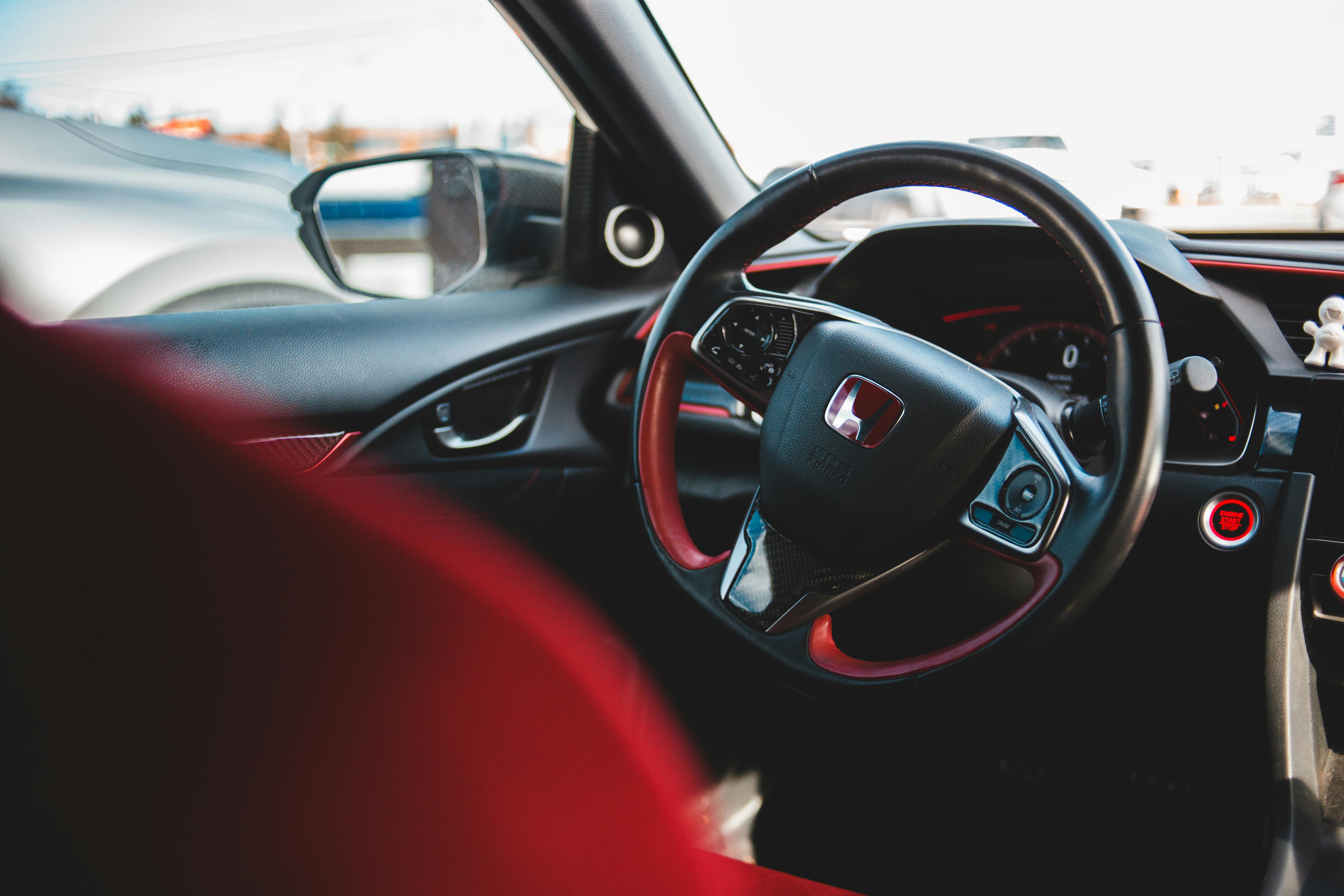 Modern car interior with steering wheel in daylight · Free Stock Photo
