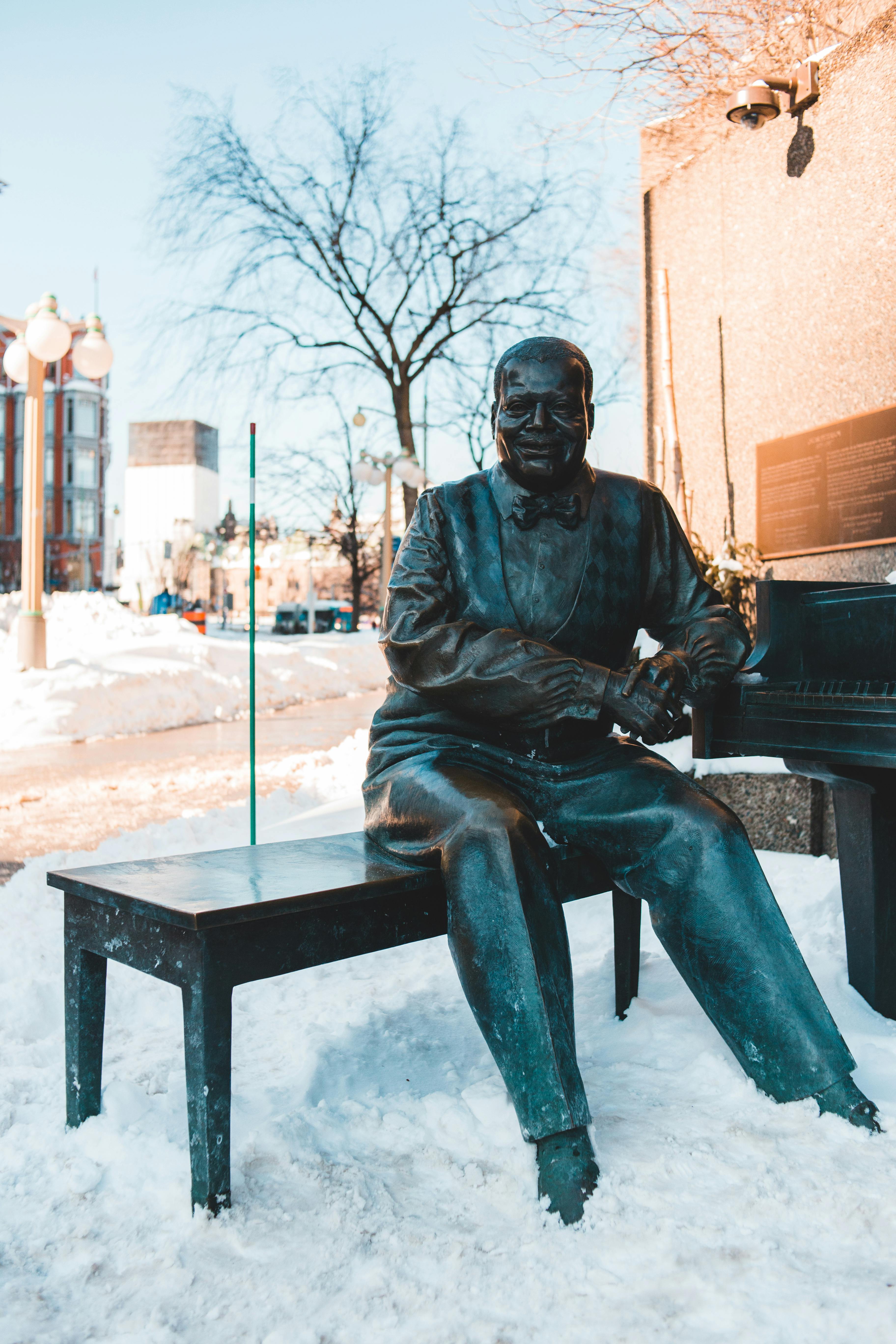 Statue of Man Sitting on Wooden Bench · Free Stock Photo