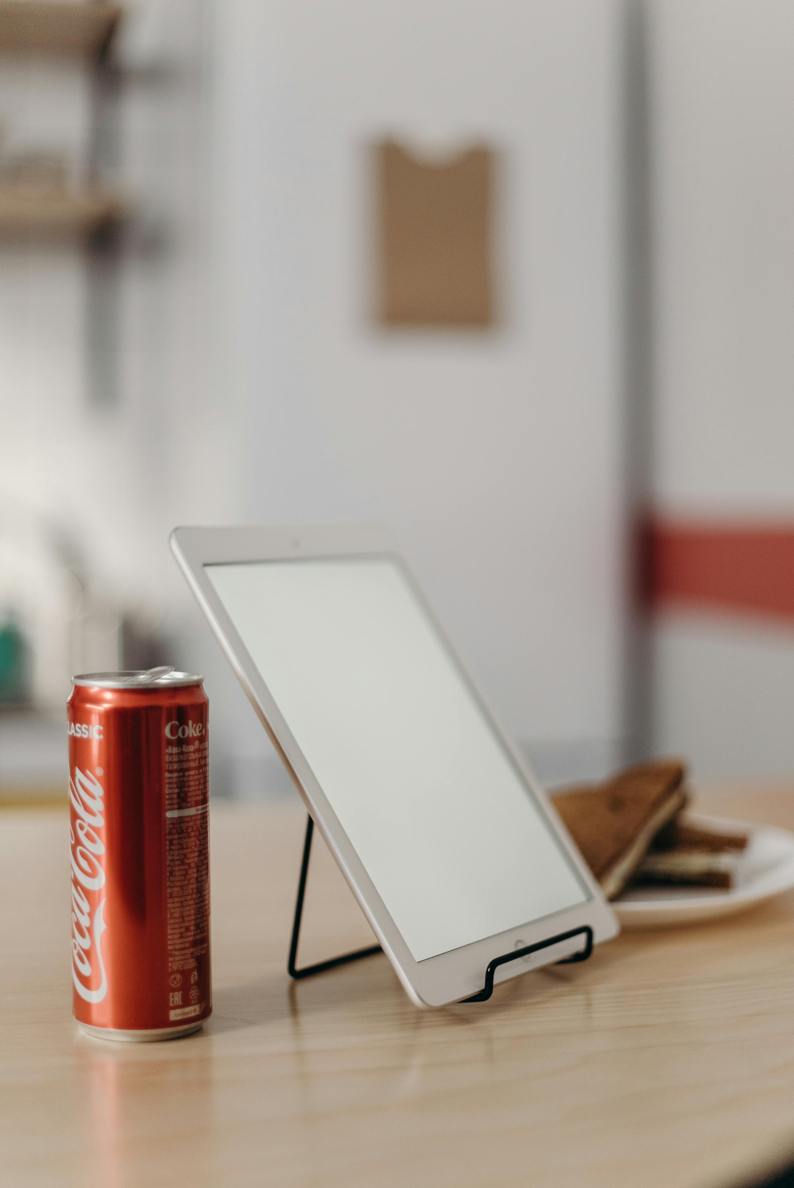 White Tablet Computer Beside Red Coca Cola Can · Free Stock Photo