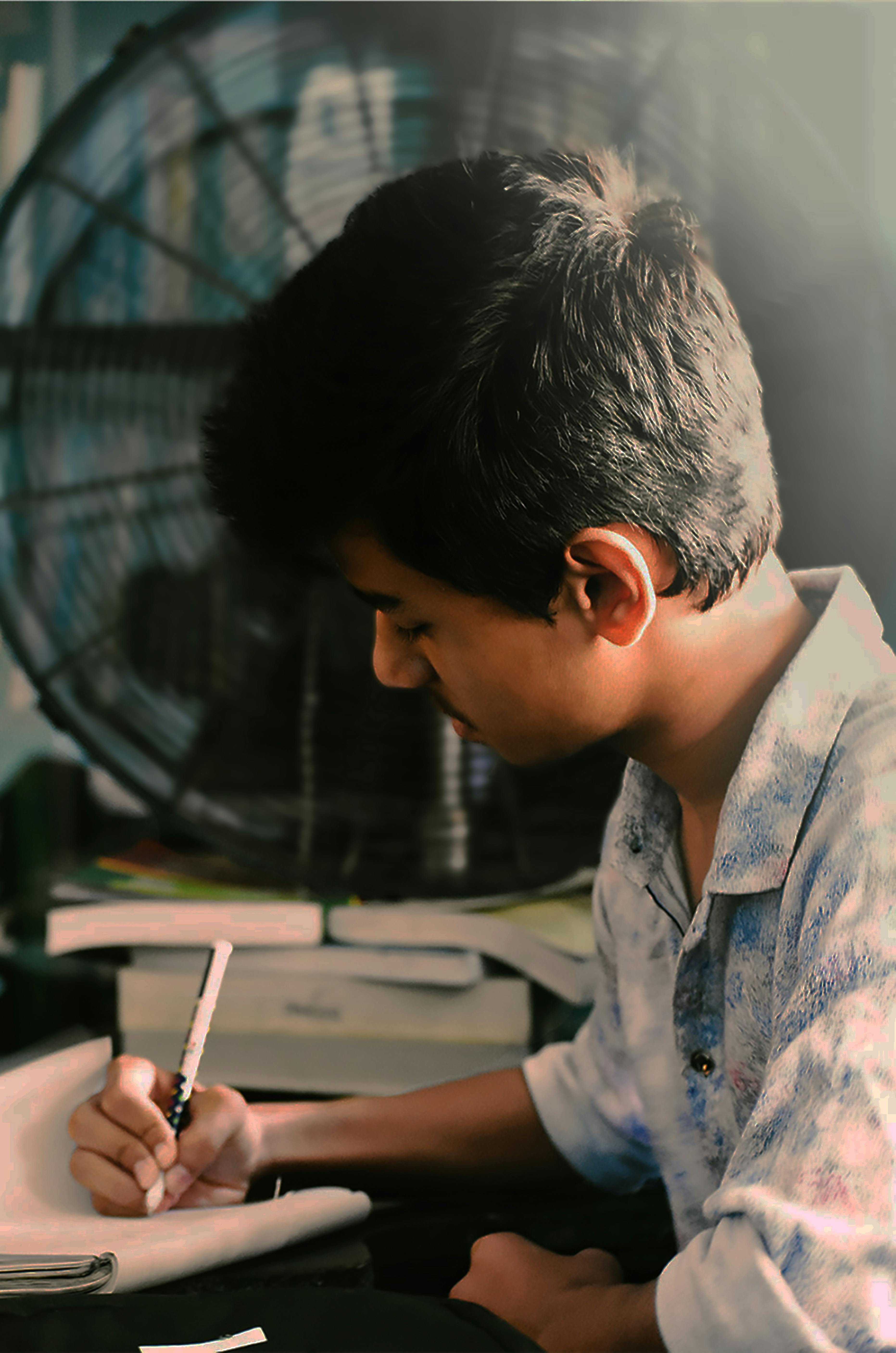 Focused Person writing on Paper · Free Stock Photo