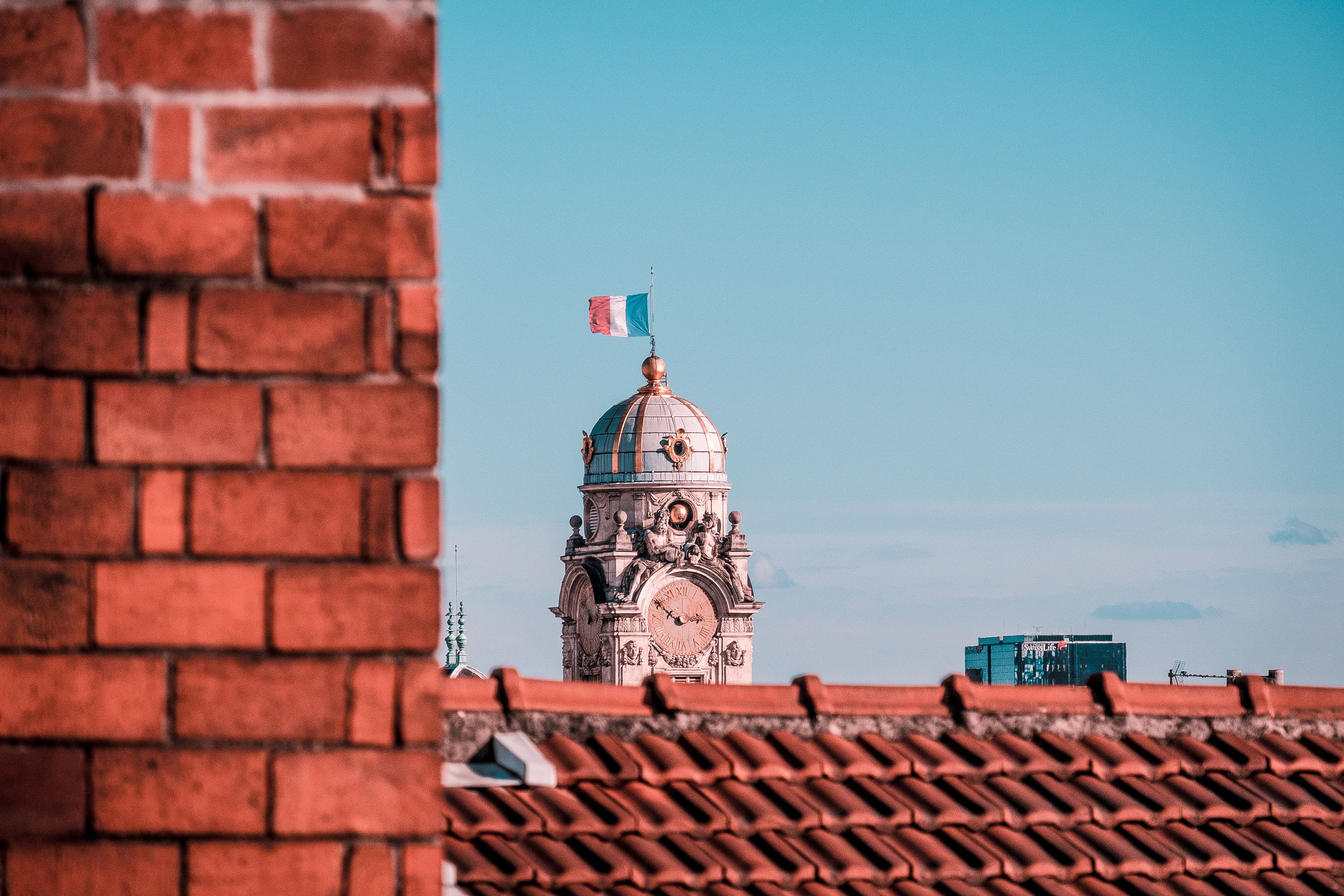 Clock Tower behind Roof Tiles · Free Stock Photo
