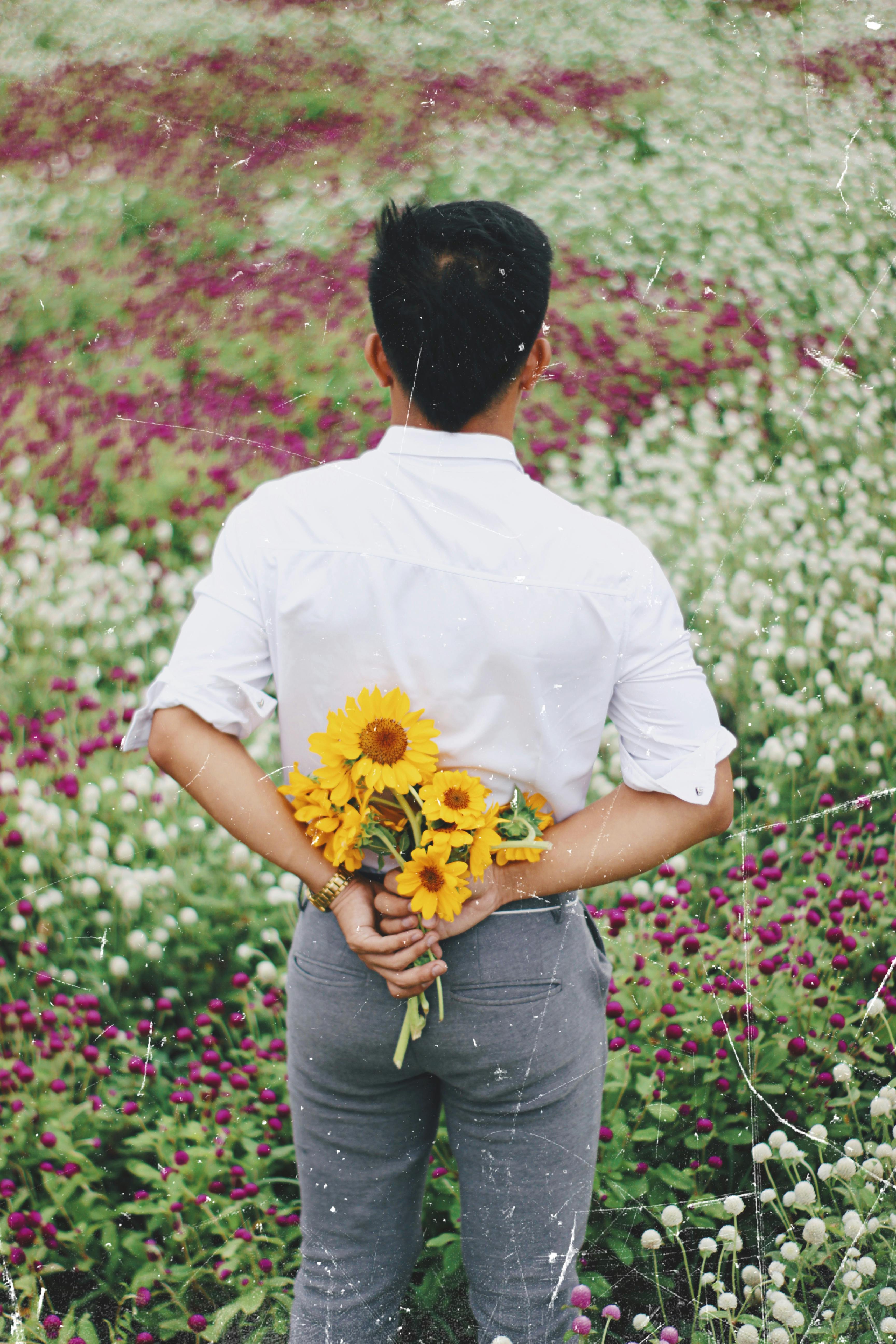 Man Holding Flowers Behind his Back · Free Stock Photo