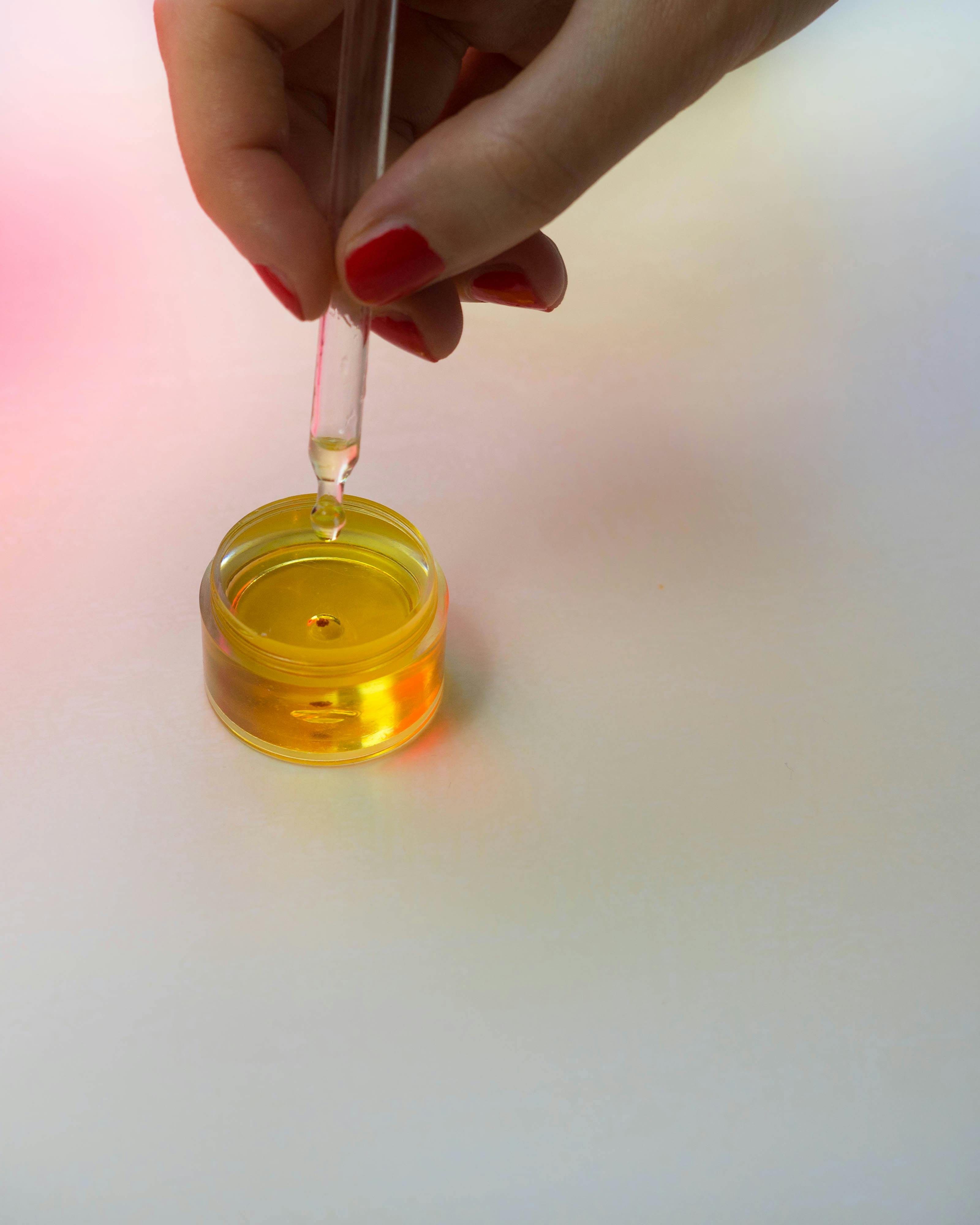 Person Holding a Dropper · Free Stock Photo