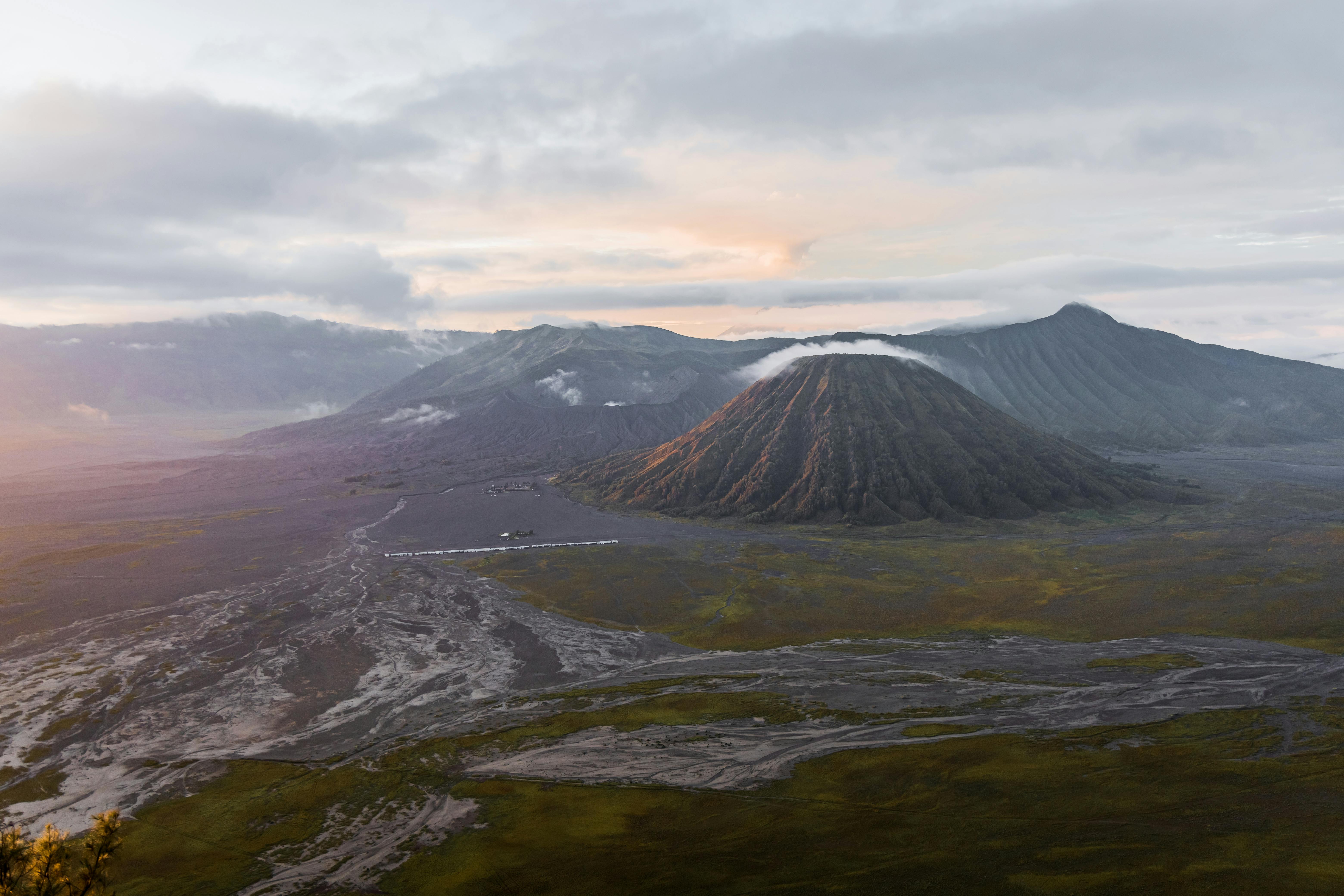 Soaring volcano in middle of mountainous area · Free Stock Photo