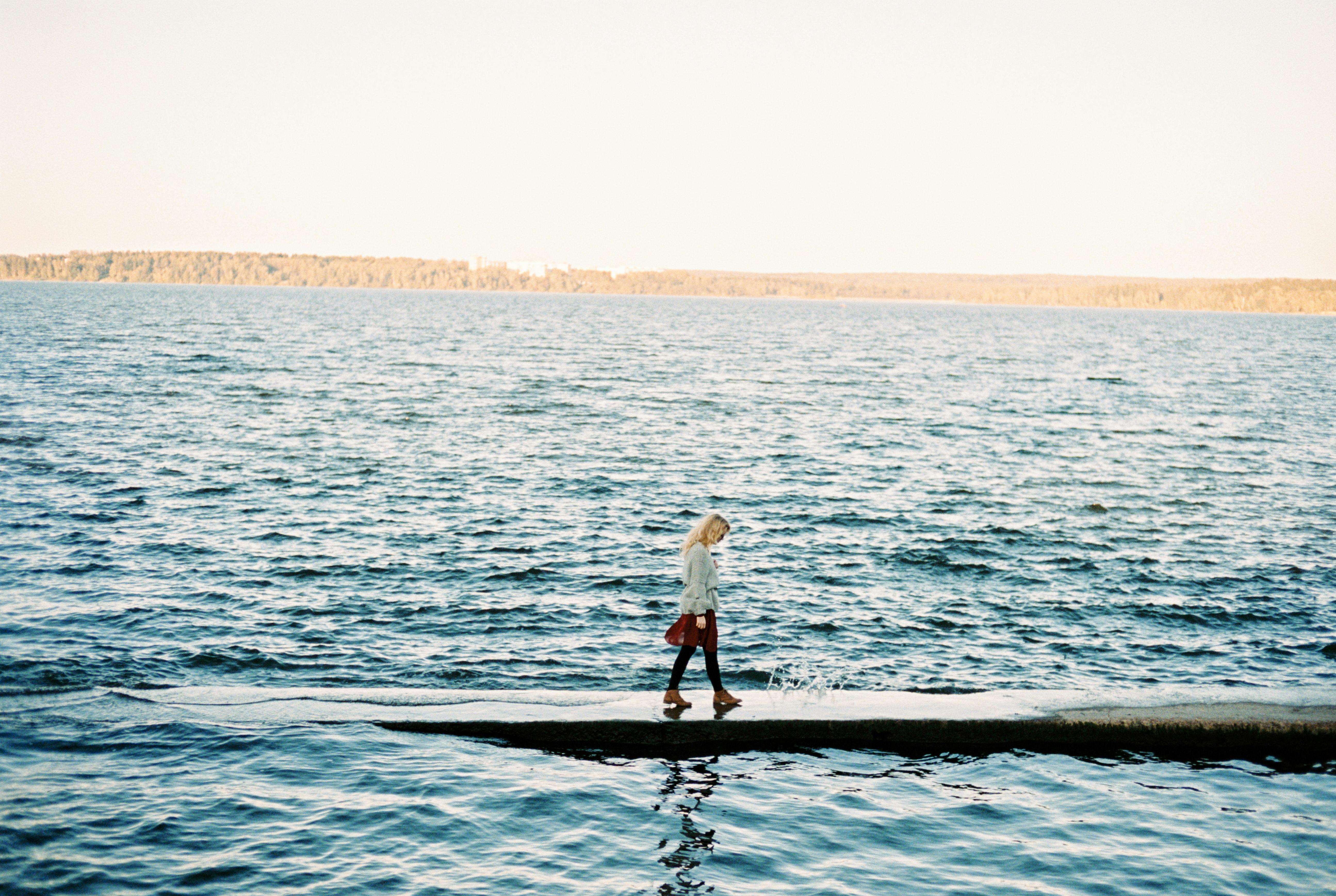 Woman Walking on a Sea Dock · Free Stock Photo