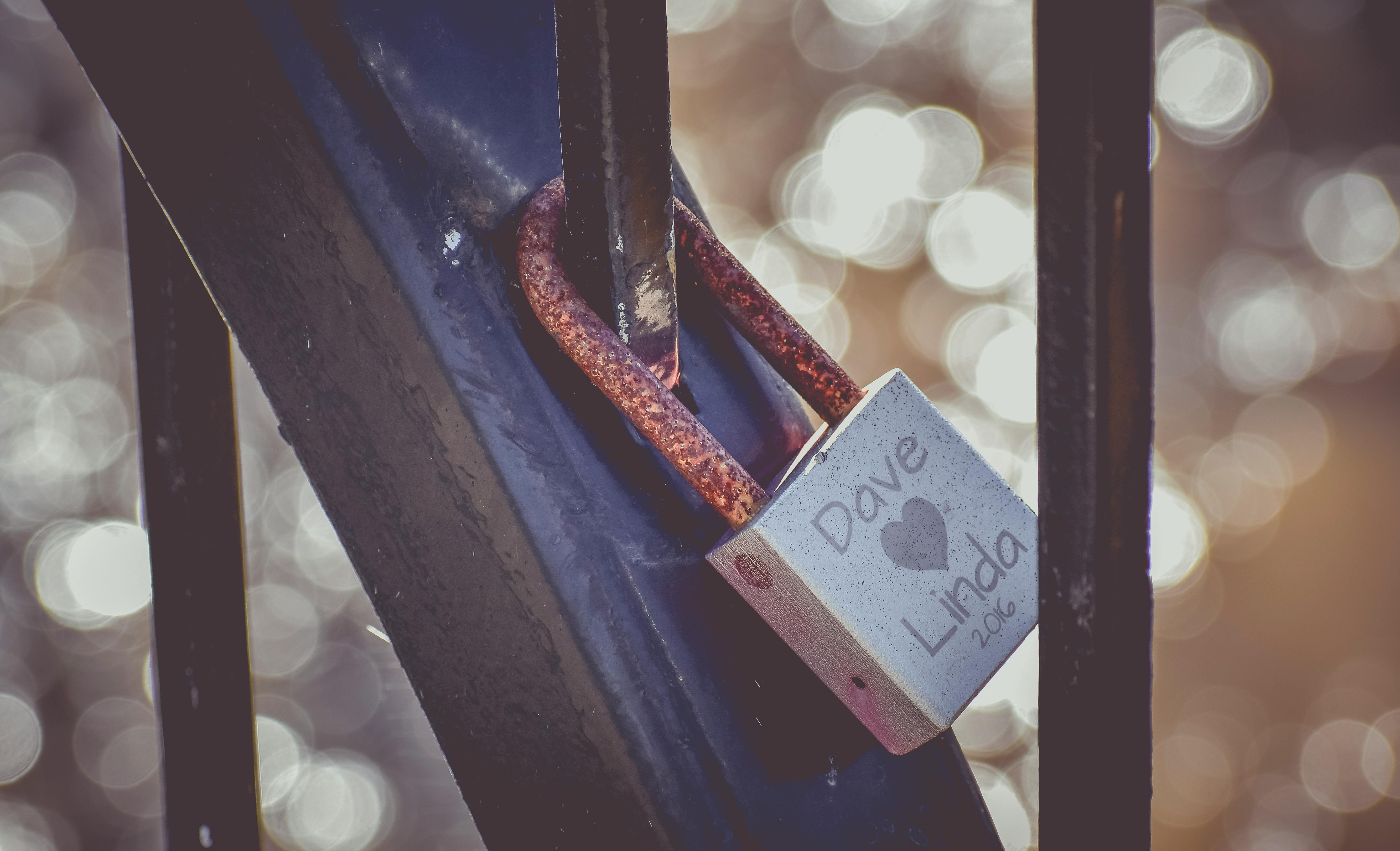 Old lock hanging on metal fence · Free Stock Photo