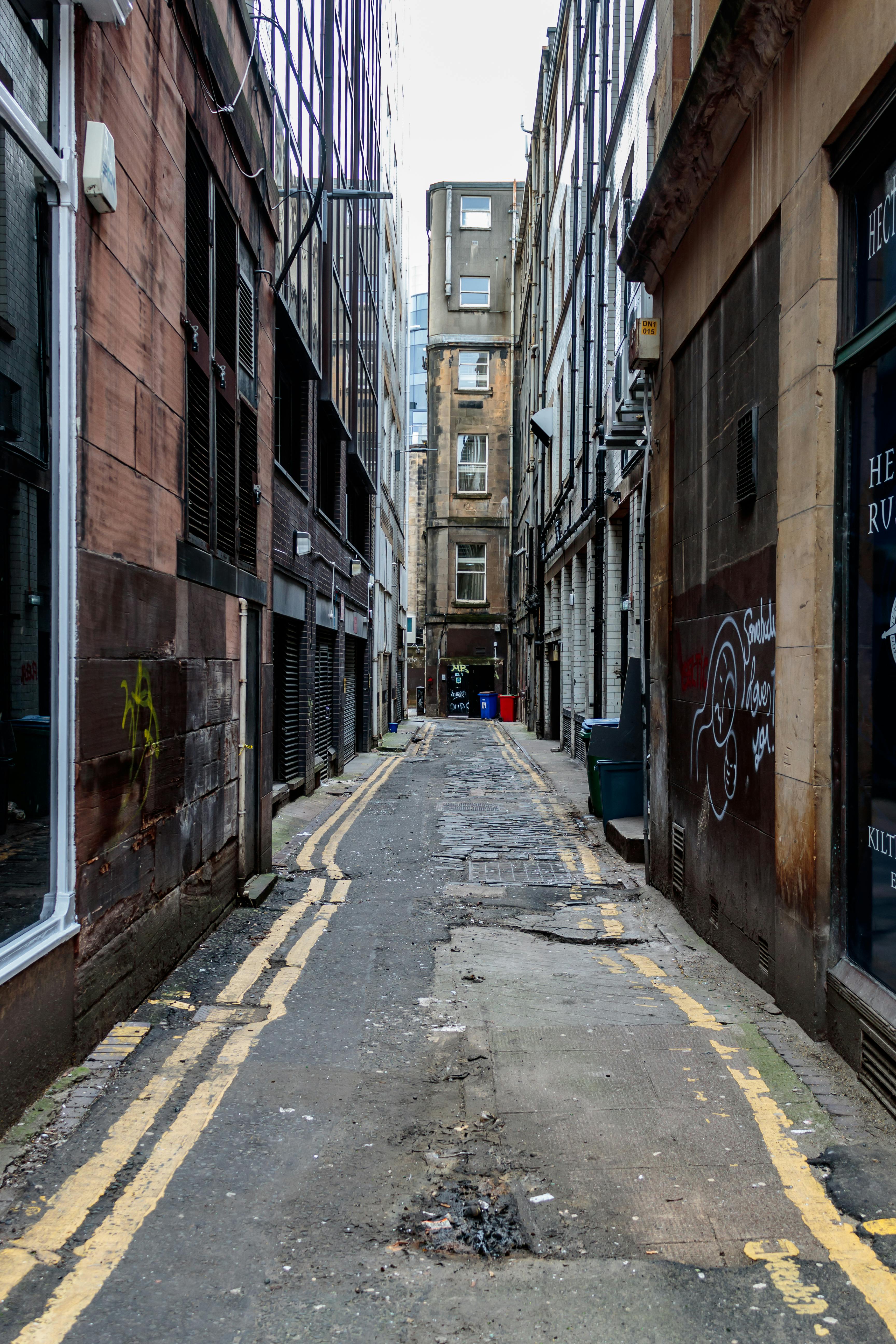 Narrow street between multistory buildings · Free Stock Photo