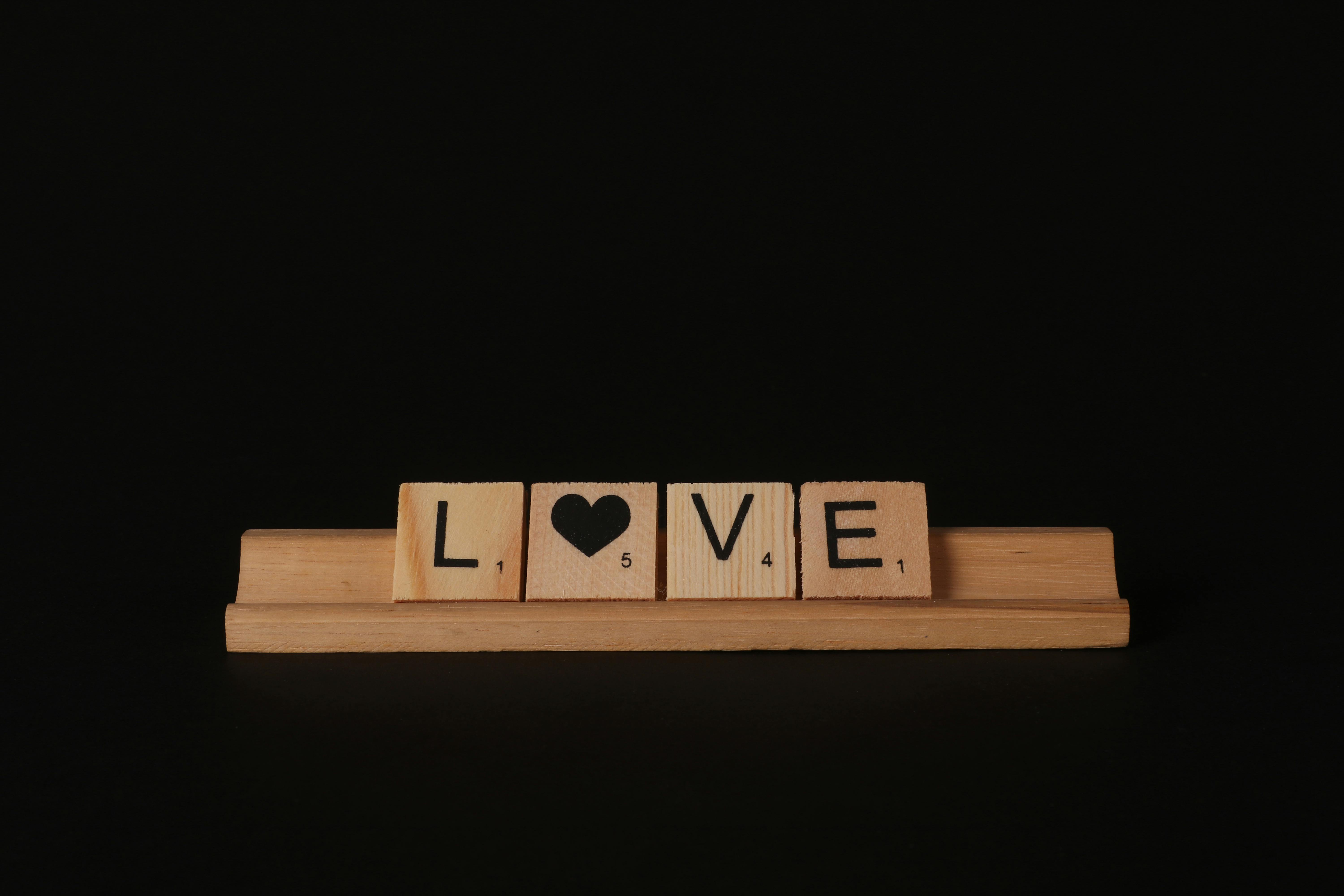 Close-Up Shot of Scrabble Tiles on a Black Surface · Free Stock Photo