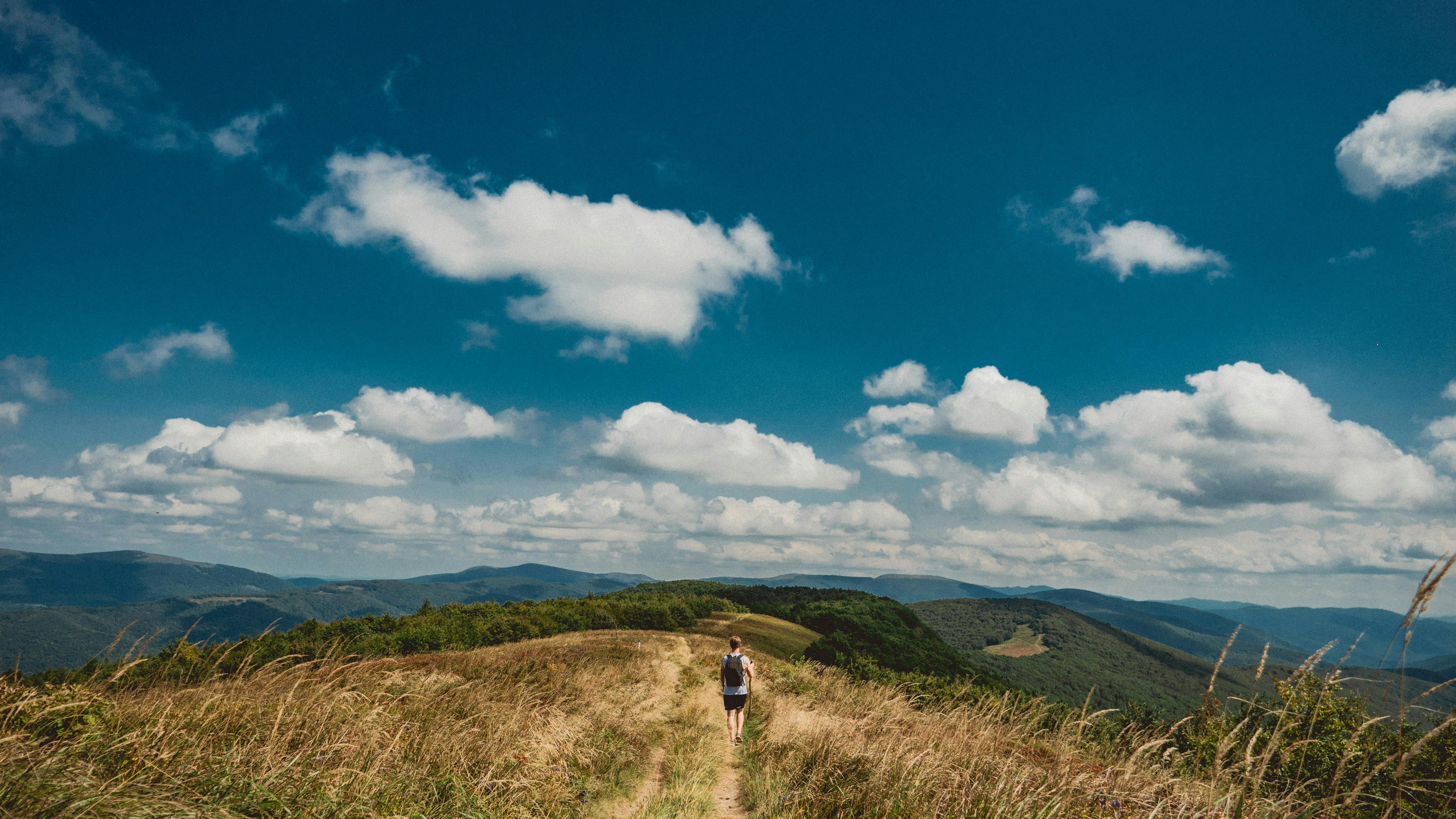 Man Walking on Grass on Top of the Mountain · Free Stock Photo